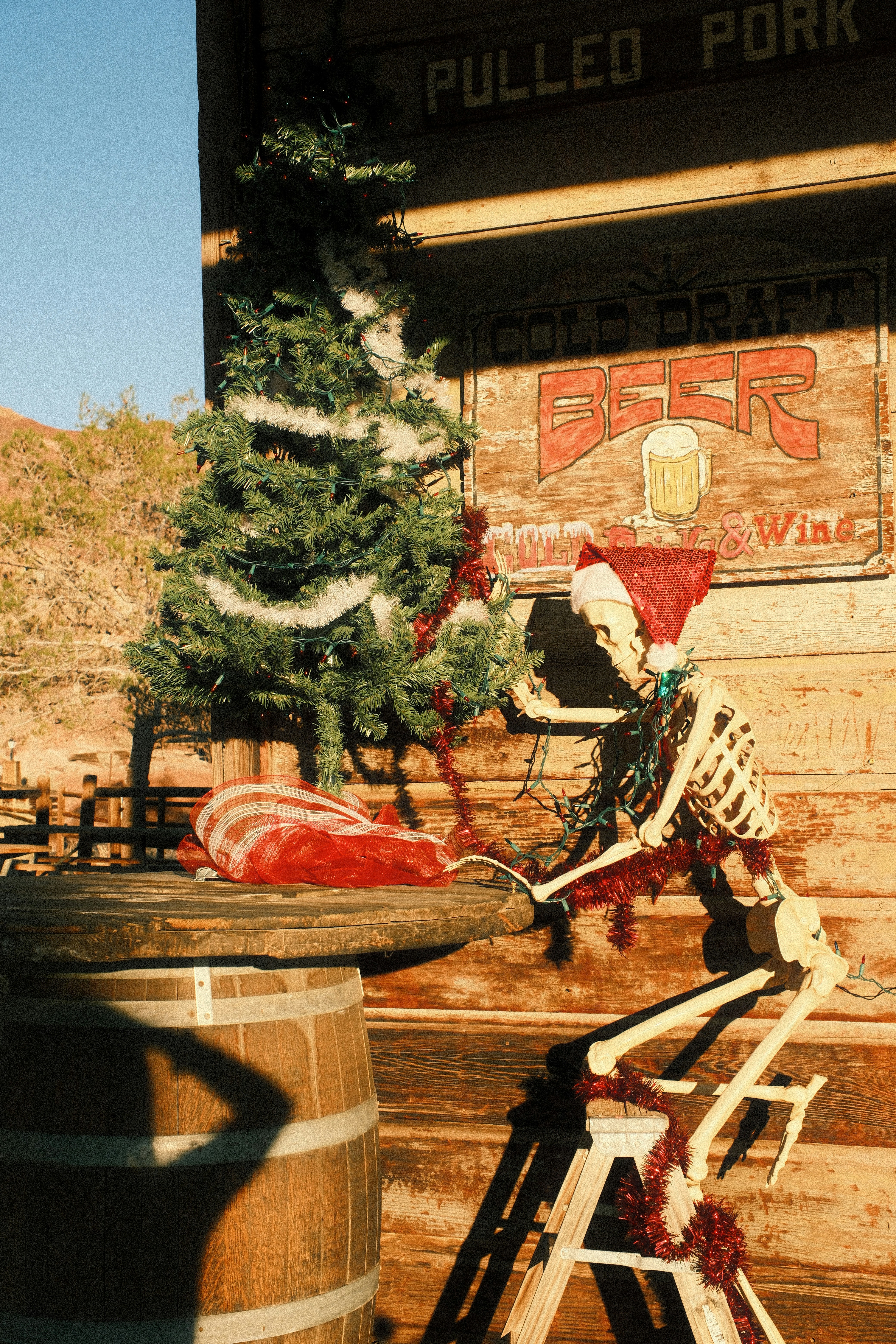 Holiday Skeleton Tending a Festive Tree at a Deserted Tavern