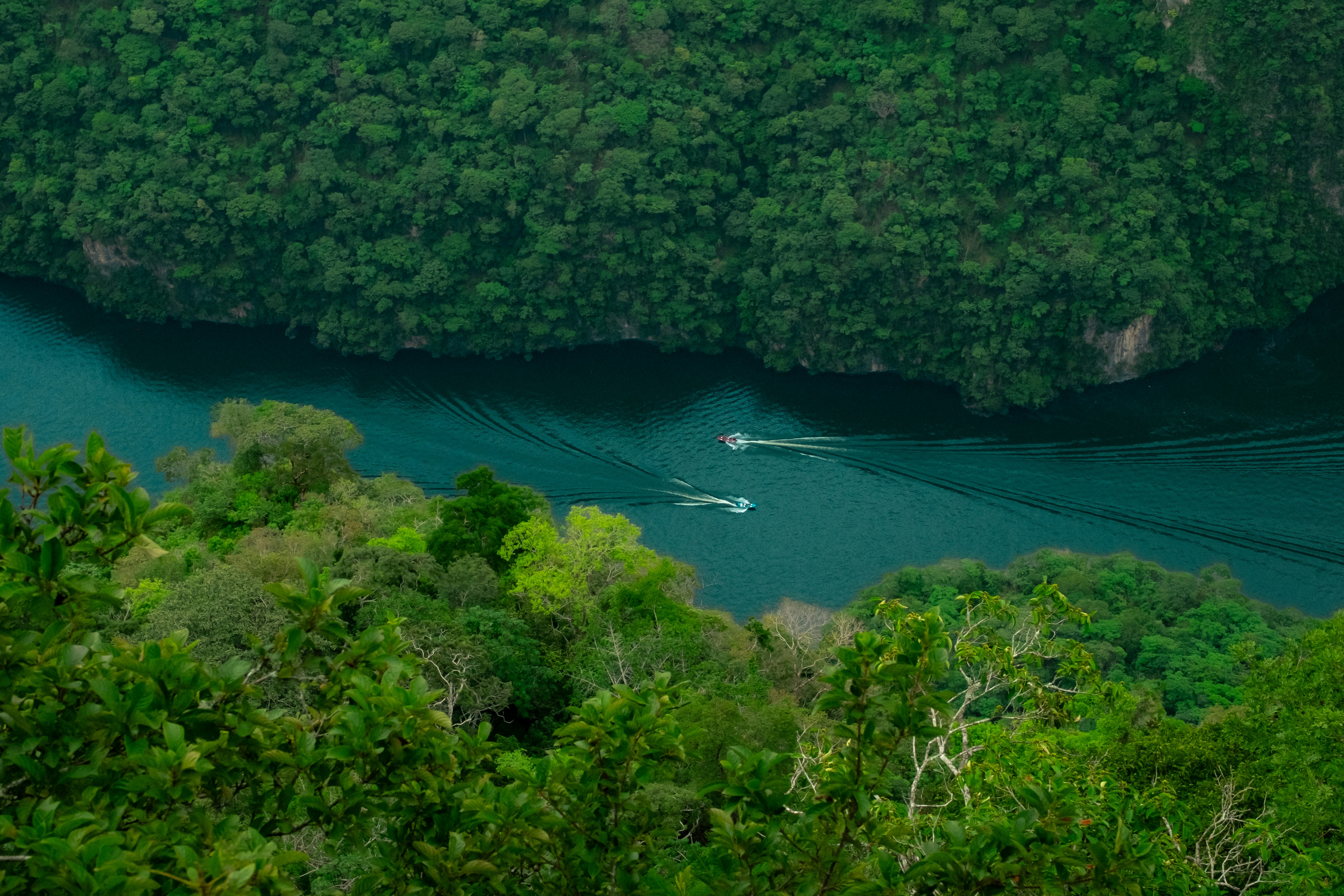 River Between the Green Ridges: A Boat Quietly Traces a Vein of Turquoise