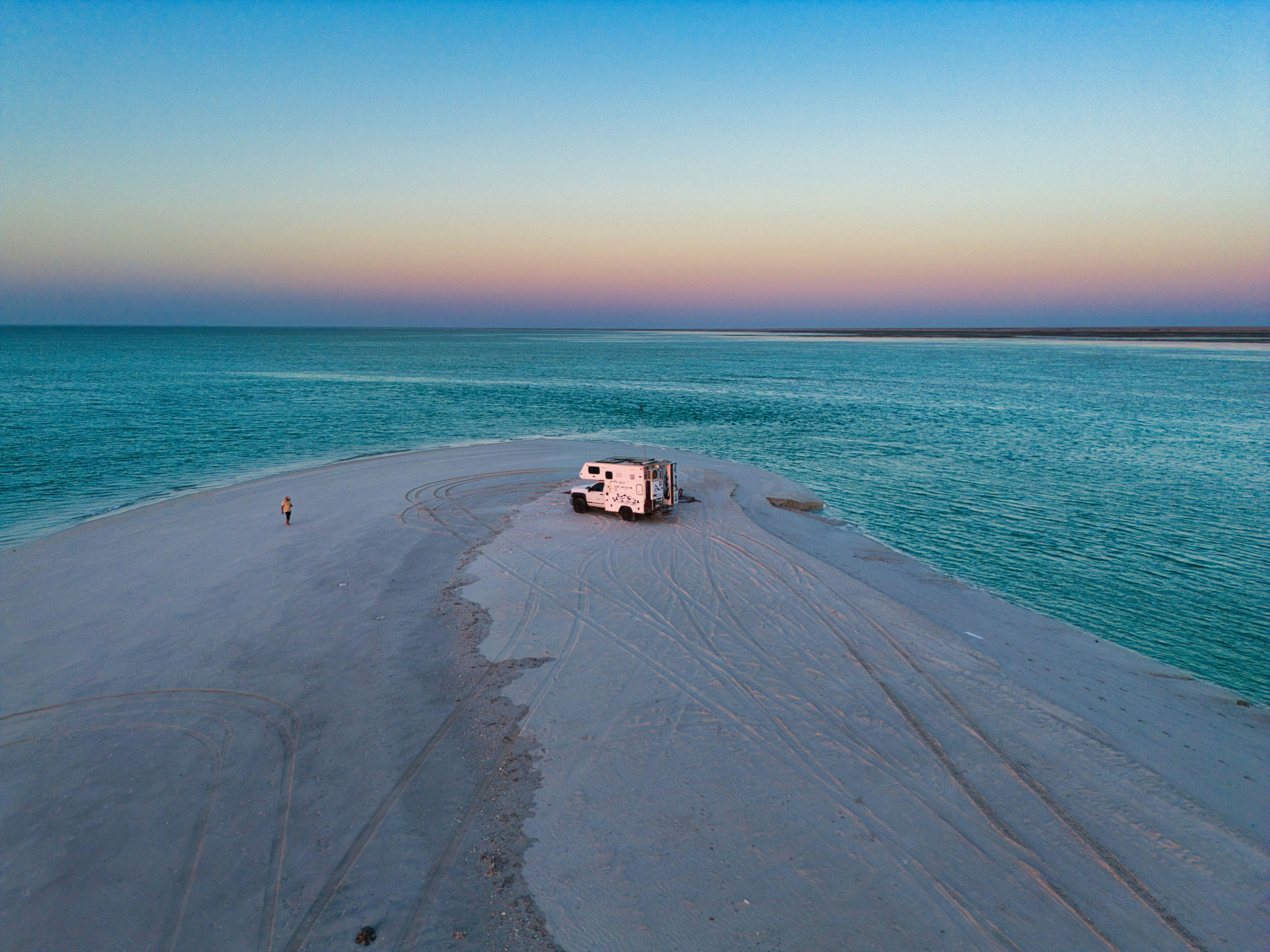 Deserted Sandbar: A lone camper on a pastel-calm spit