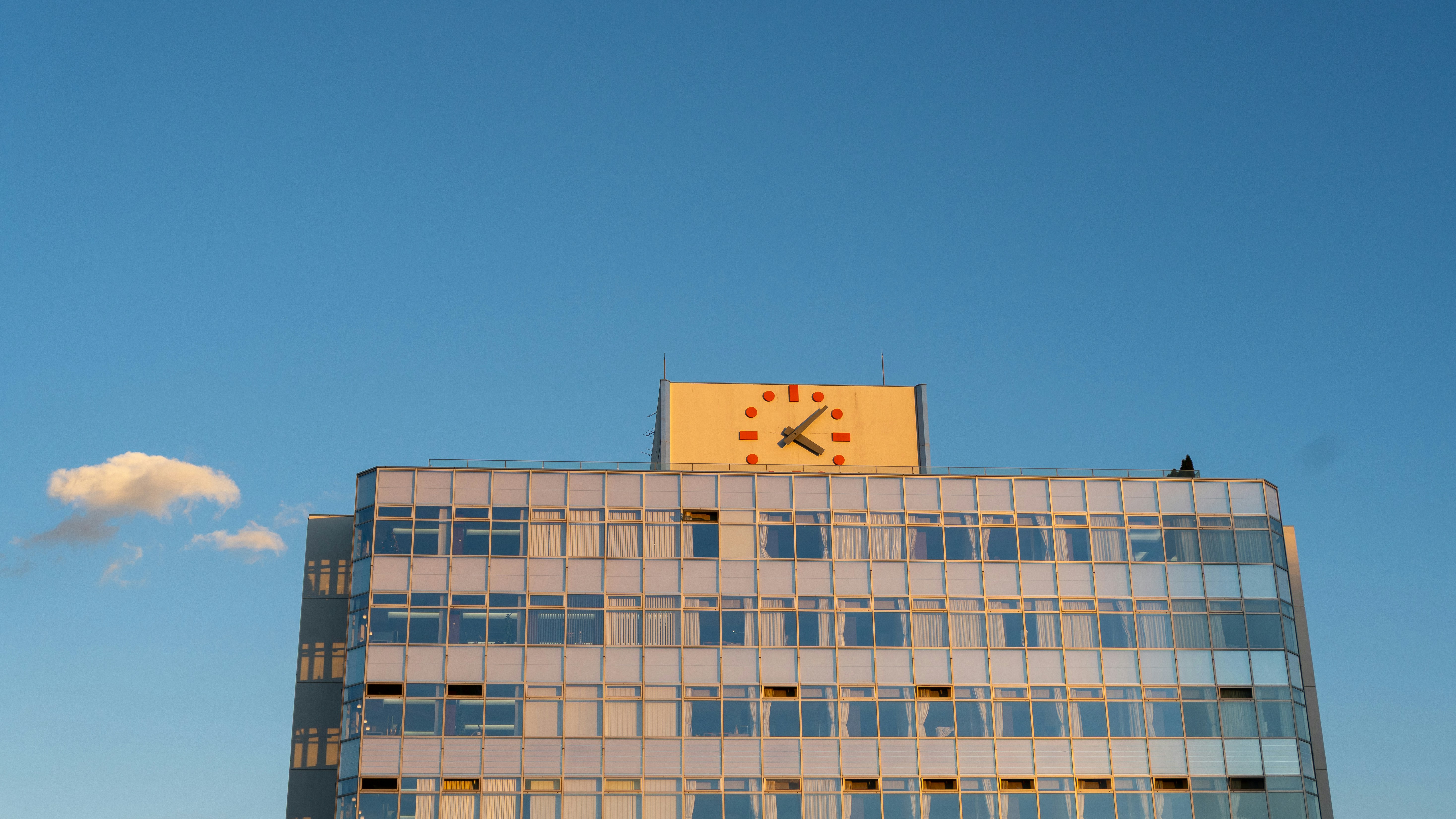 Clock Tower Over Glass Facades at Dusk