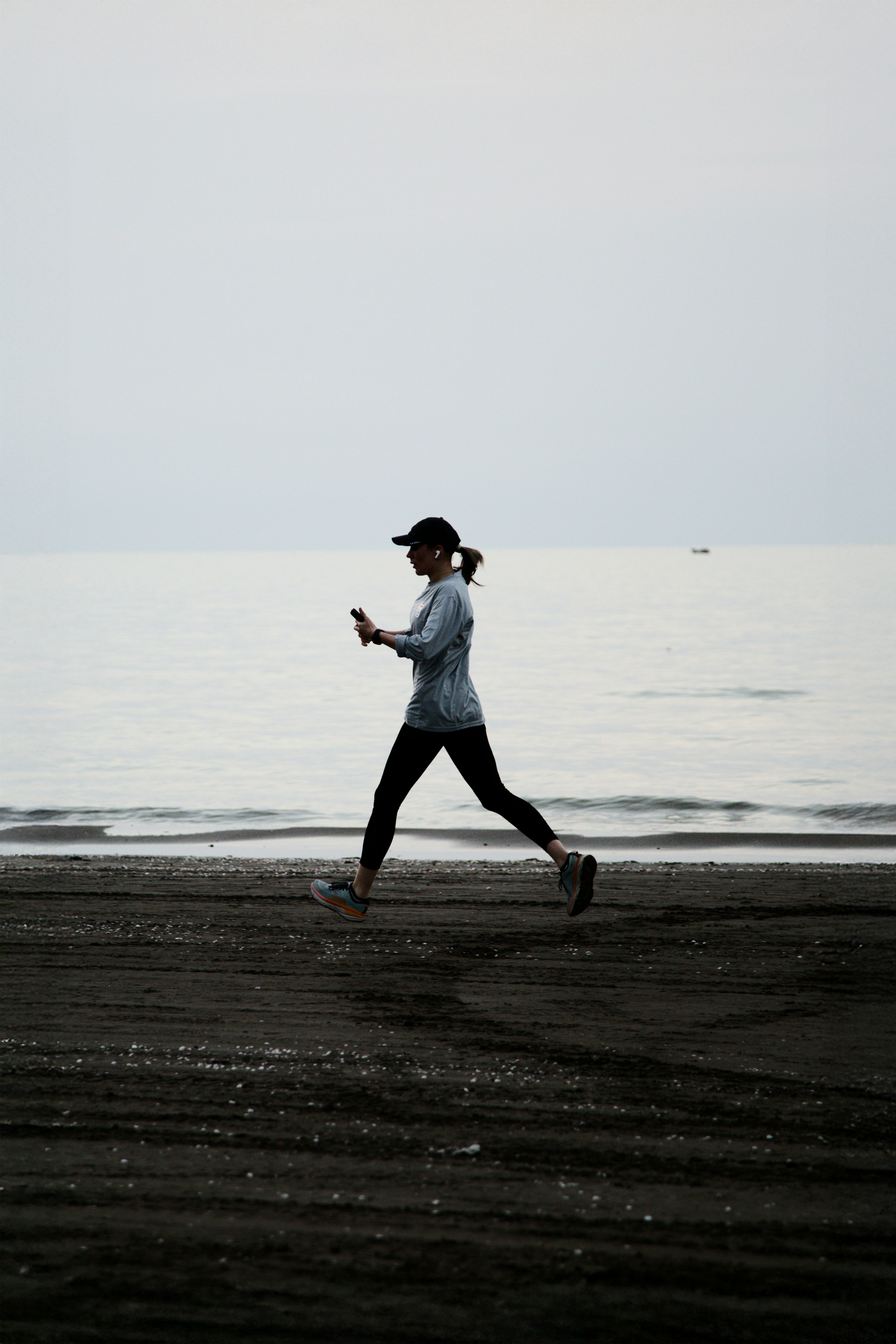 Energetic Beach Run: A Runner in Mid-Leap Along the Shore