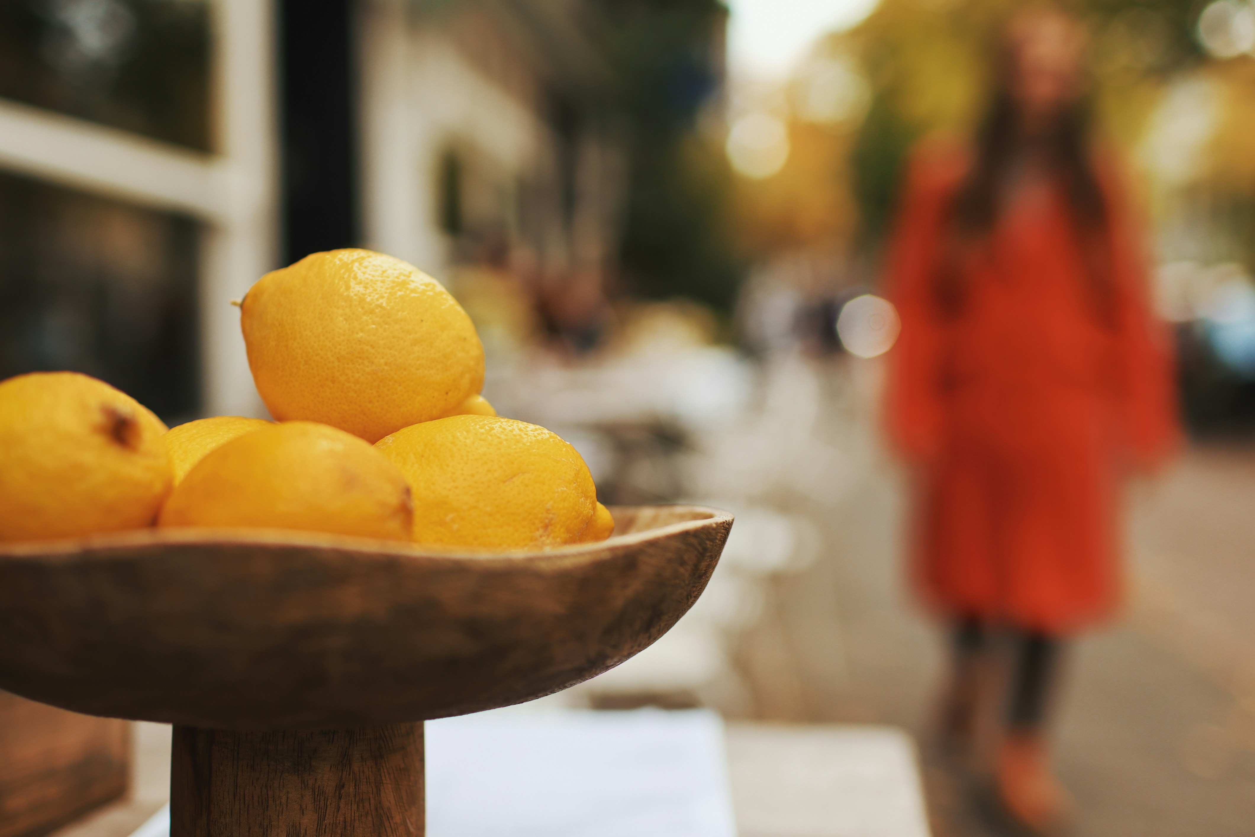 Lemons on a pedestal: street scene with a blurred passerby