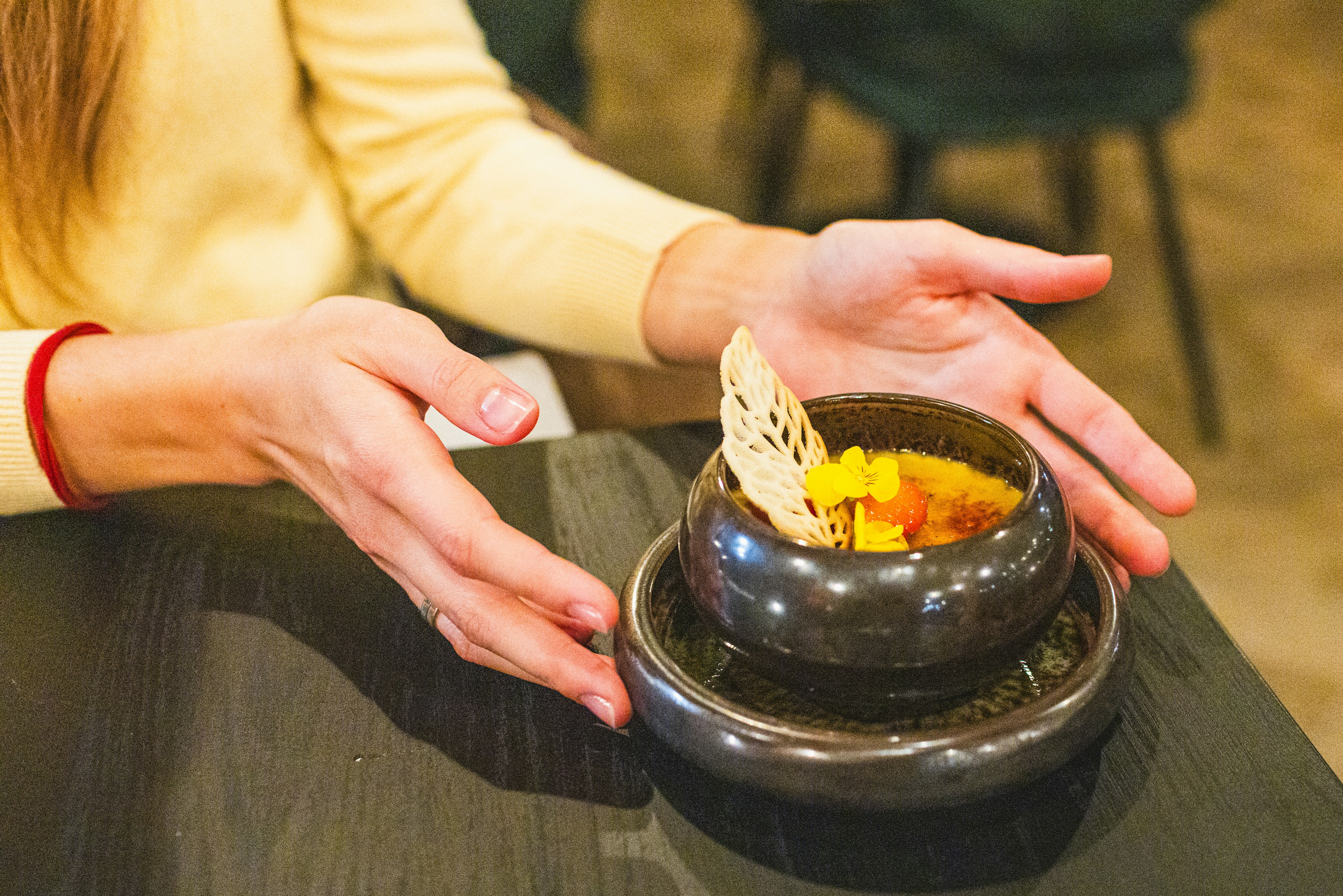 Hands Framing a Saucer of Golden Garnishes