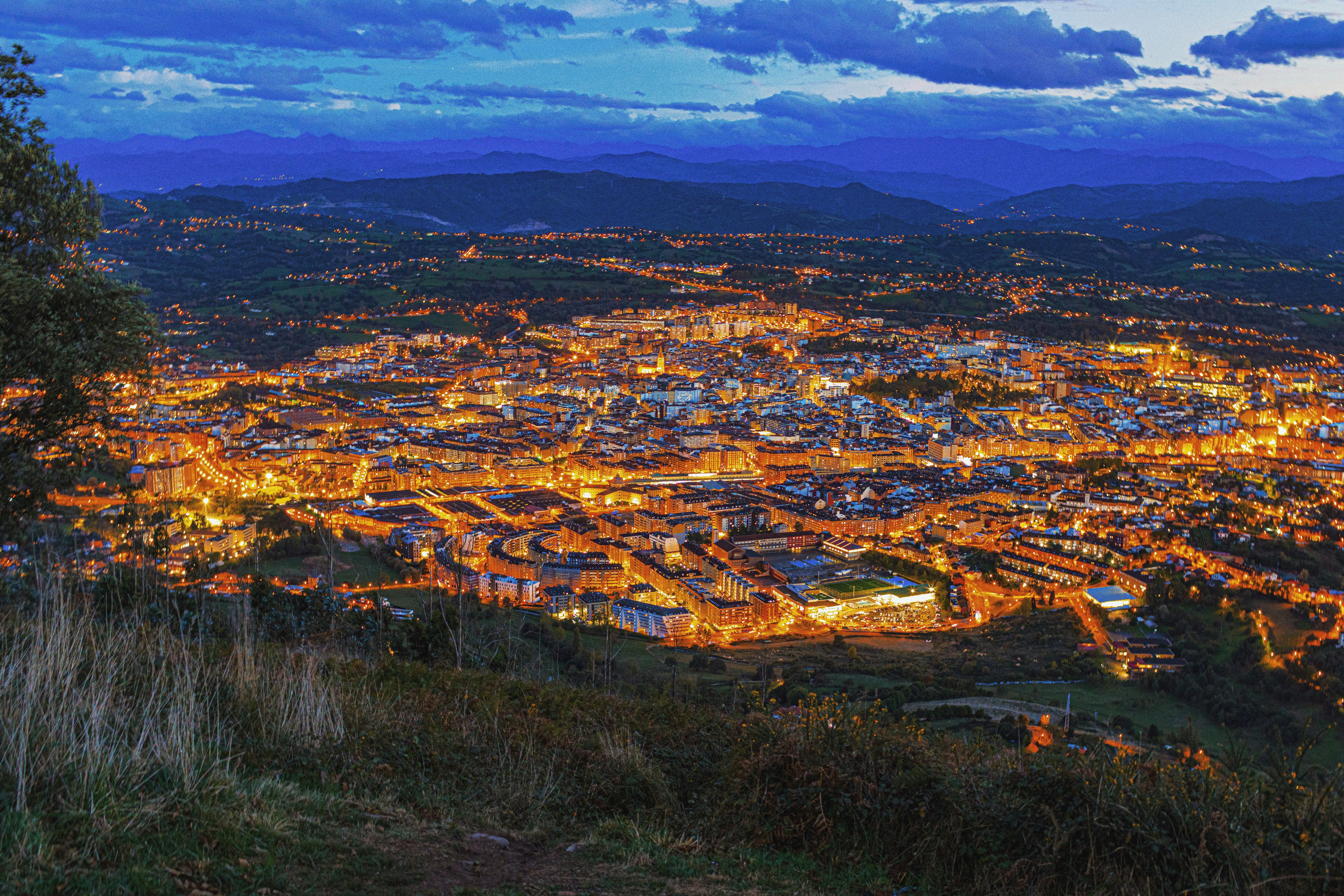 City Lights Bloom Over Rolling Hills at Dusk
