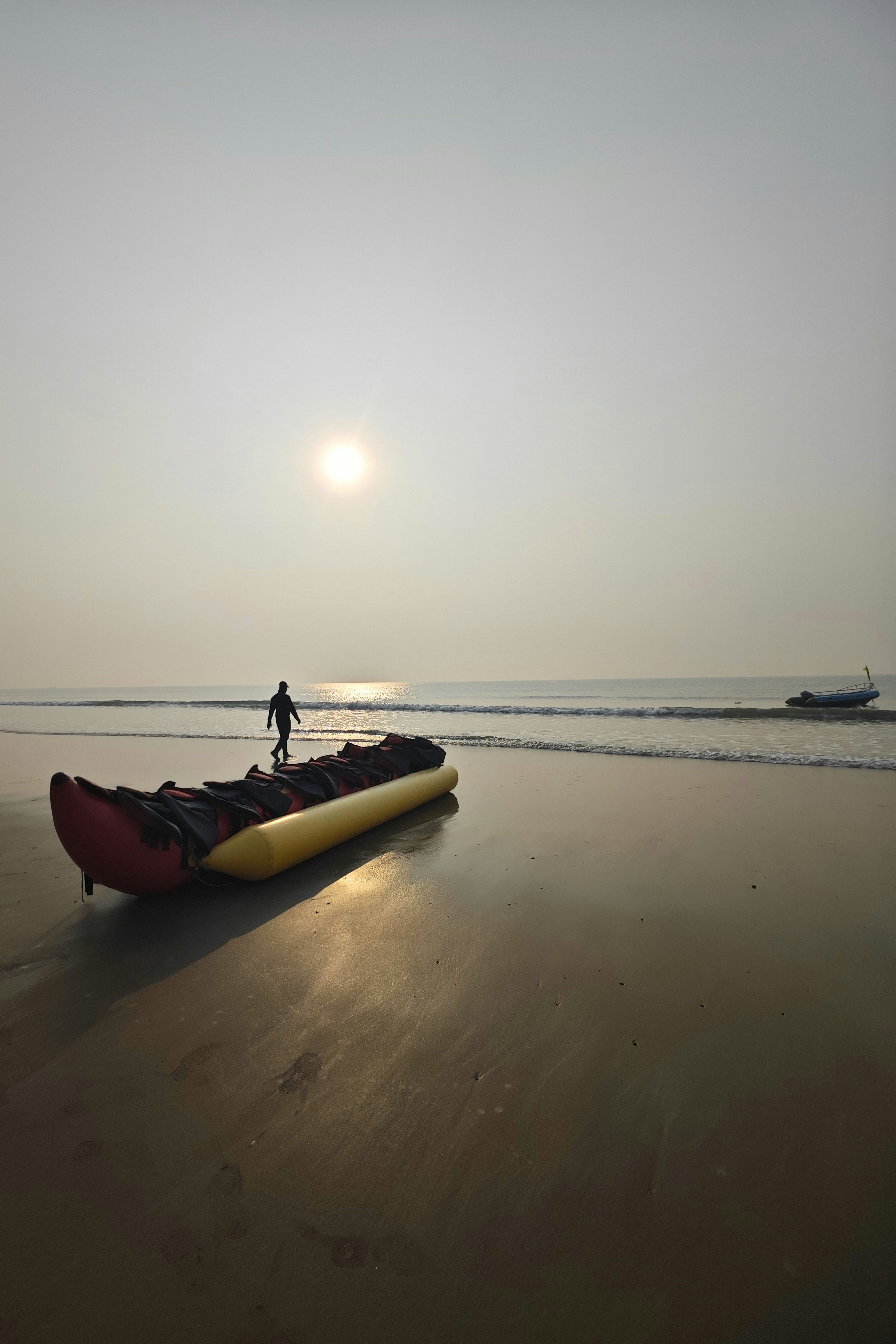 Silhouette by the Tidal Line: A Person and Raft on a Quiet Sunset