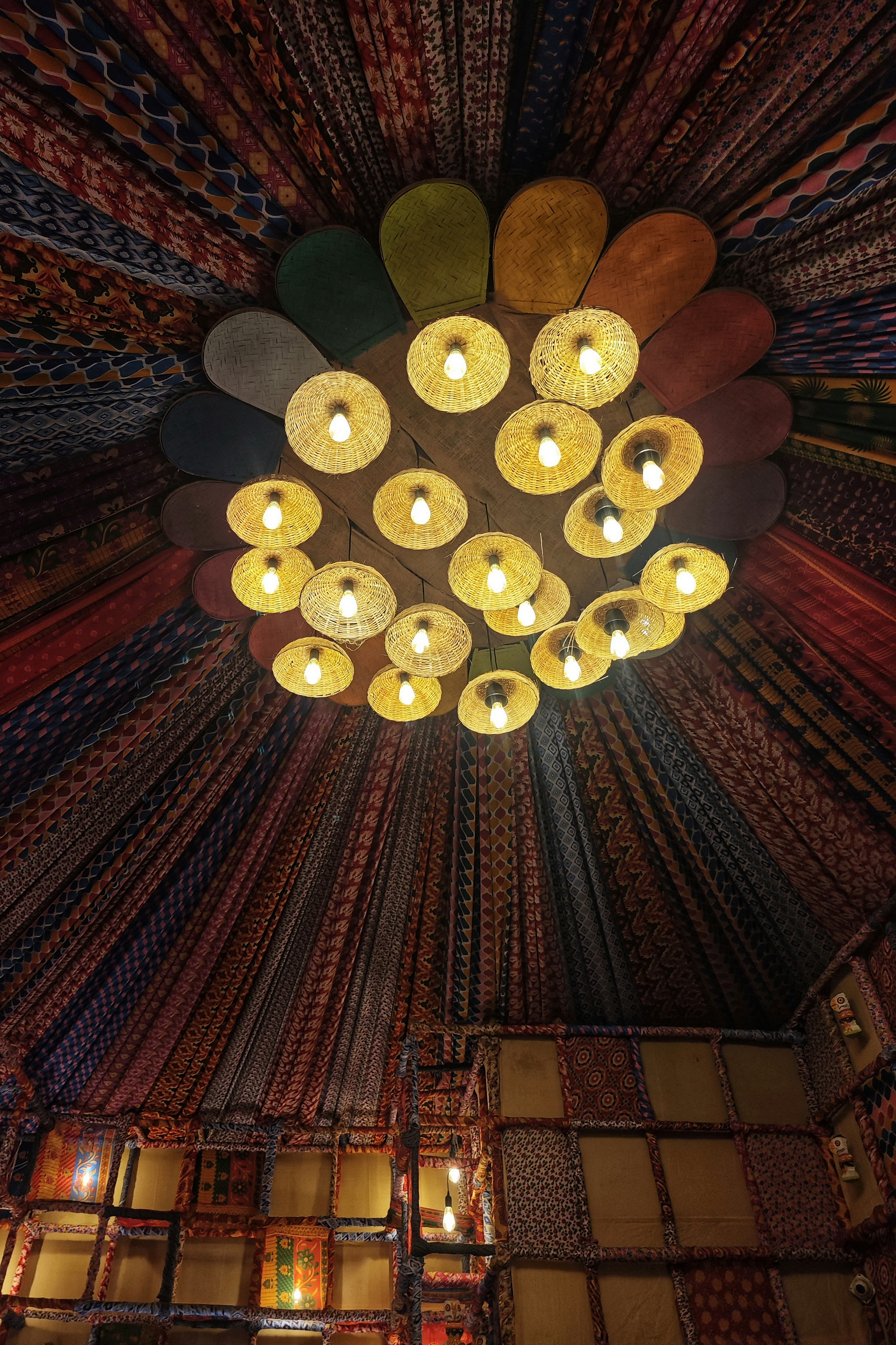 Colorful patterned fabric ceiling with hanging lights.
