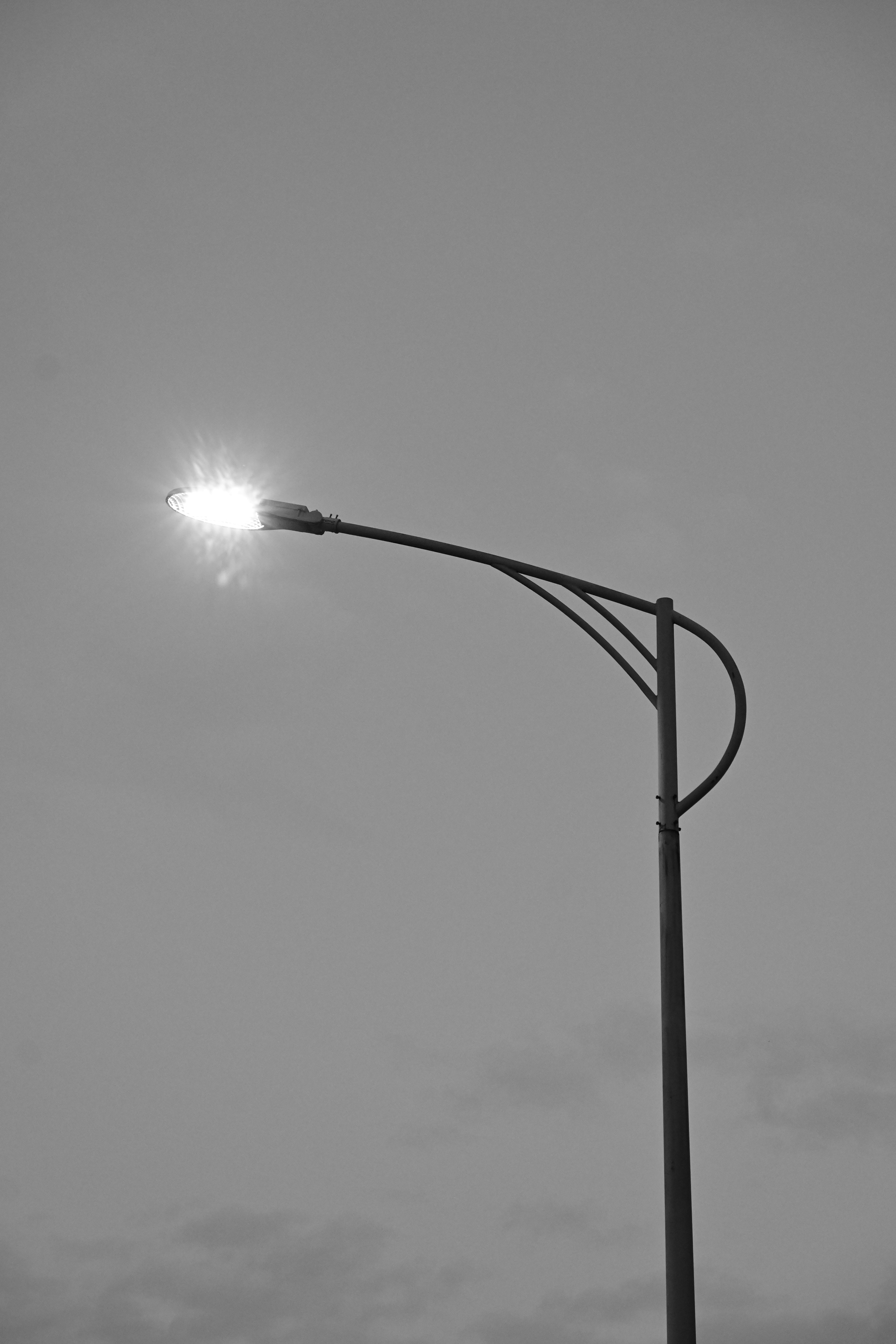 Solar flare on a curved street lamp silhouette