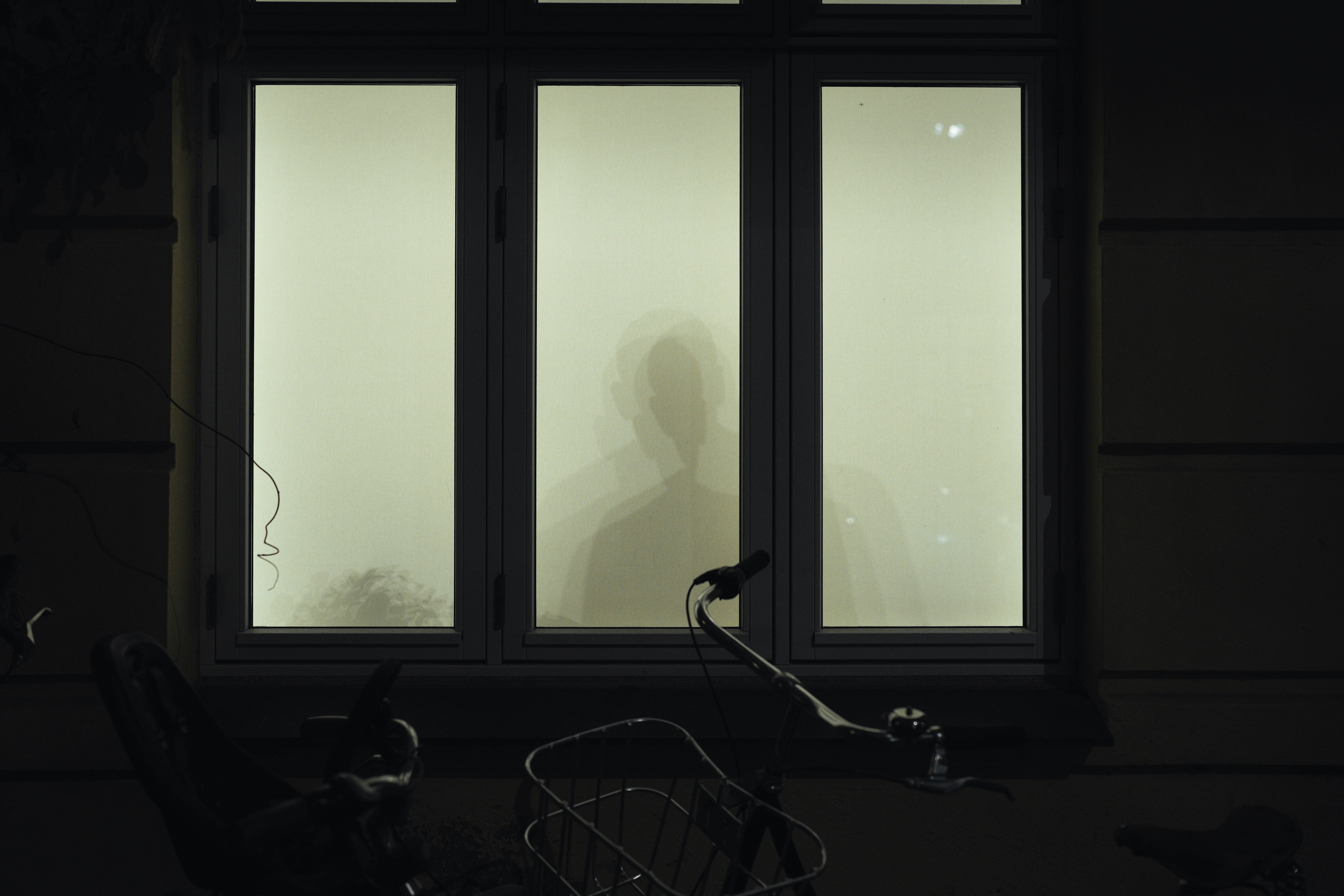 Midnight Window: Silhouette Behind Fogged Glass
