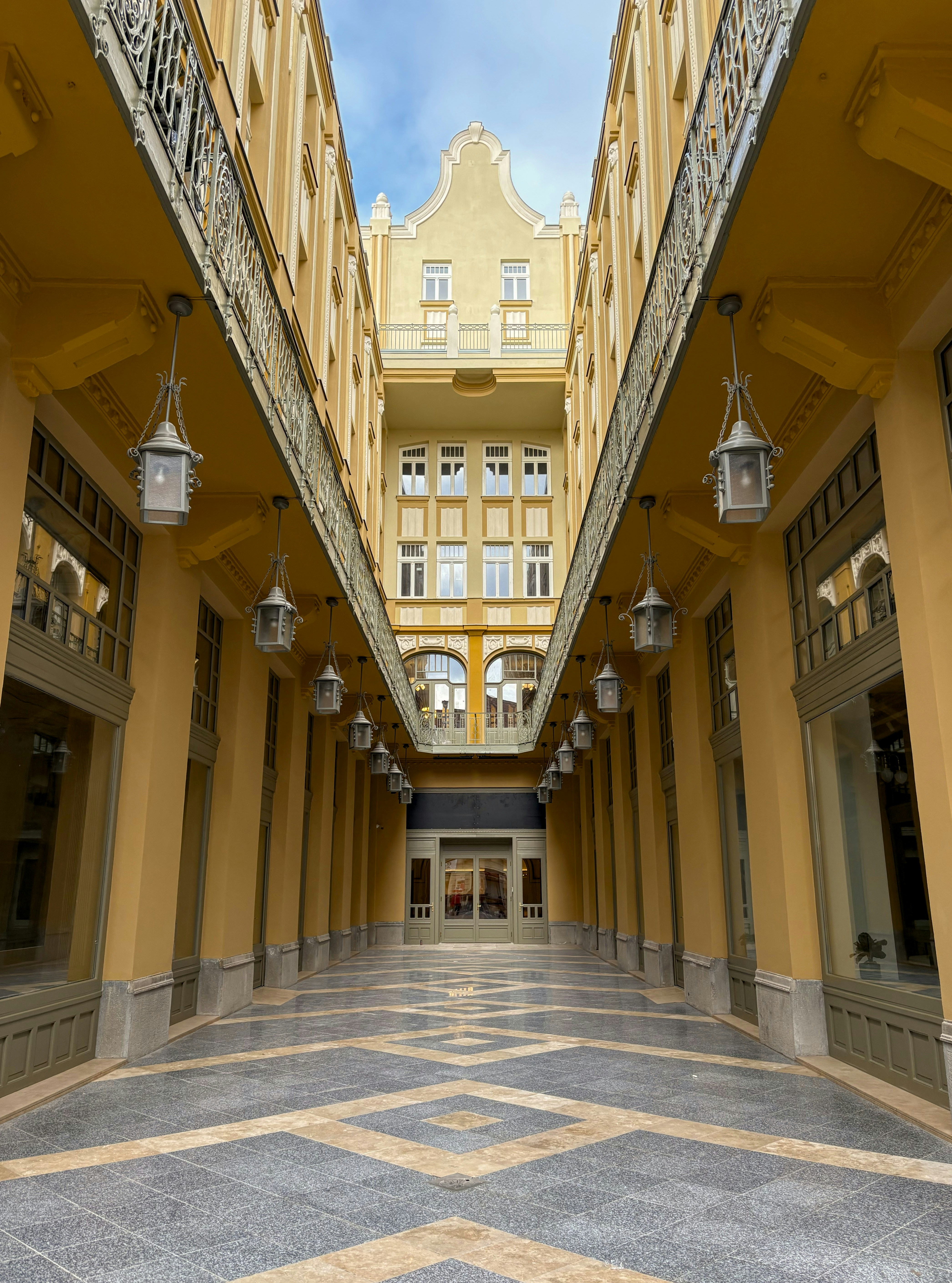 Yellow building with an ornate walkway and lanterns