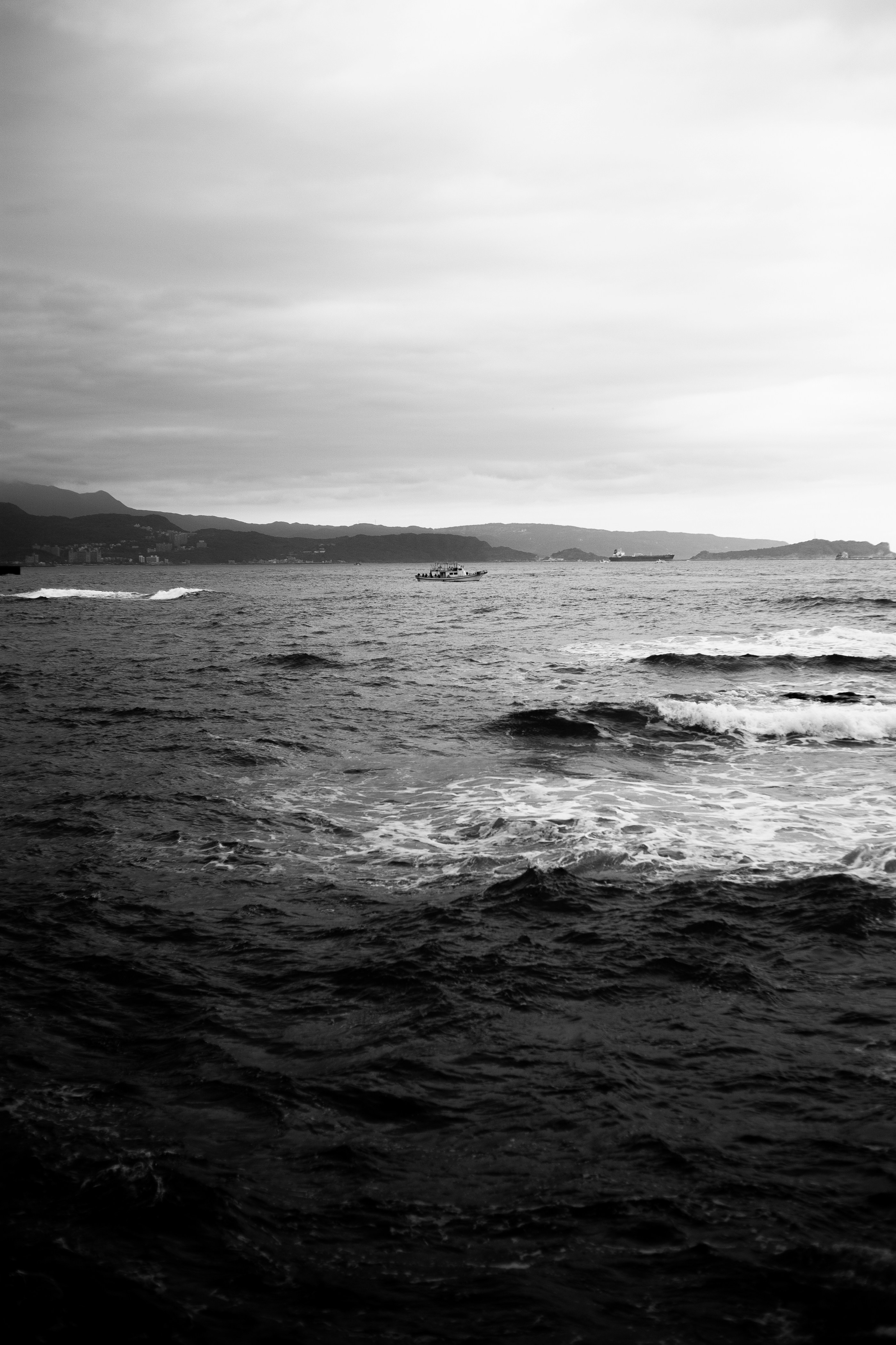 Quiet Horizon: A Distant Boat Against a Monochrome Sea