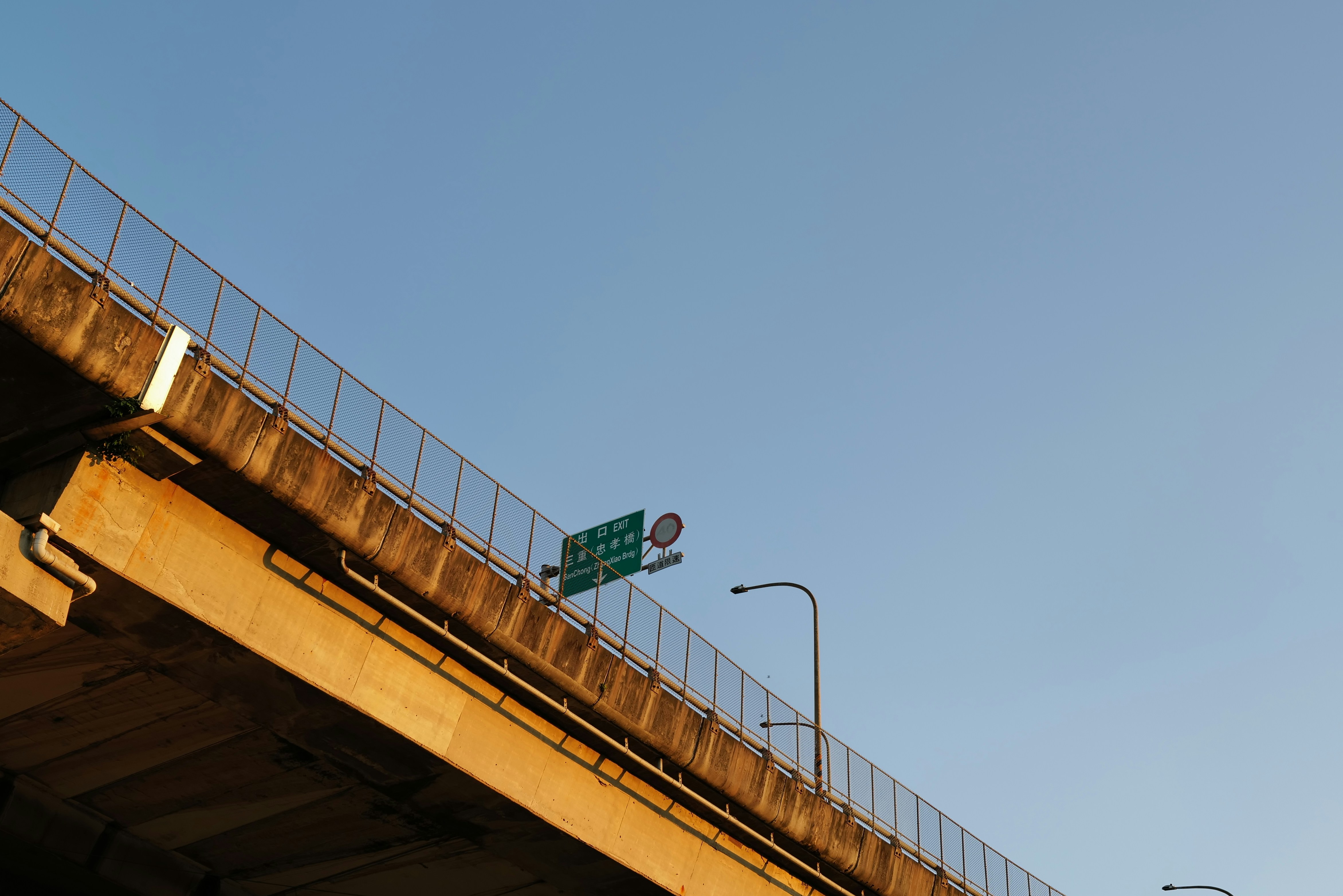 Overpass Edge: A Street Sign Against a Clear Sky