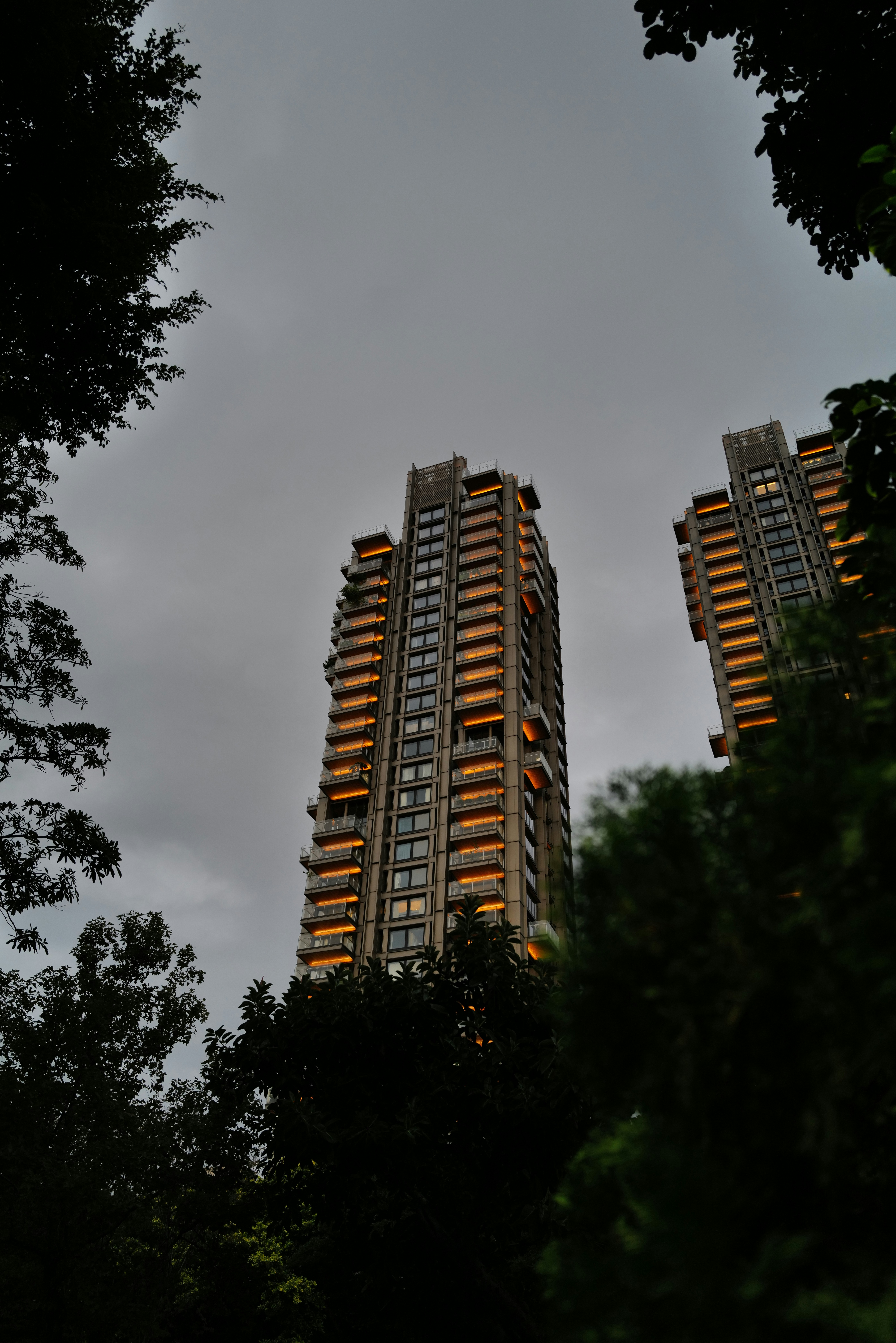 Twin Towers Reach Through Grey Skies as Evening Light Warms the Facades