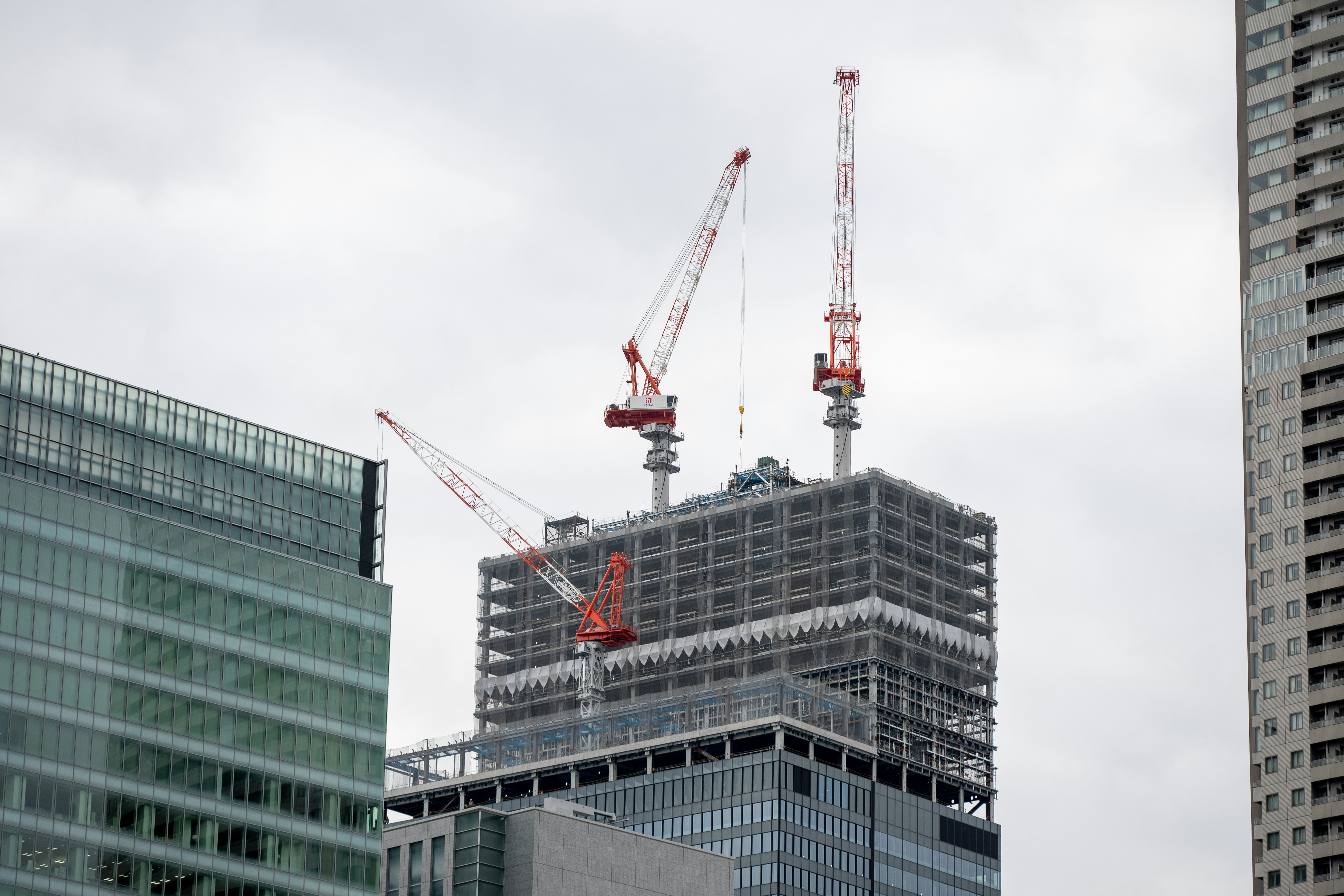 Towering Cranes Above a Modern Skyline