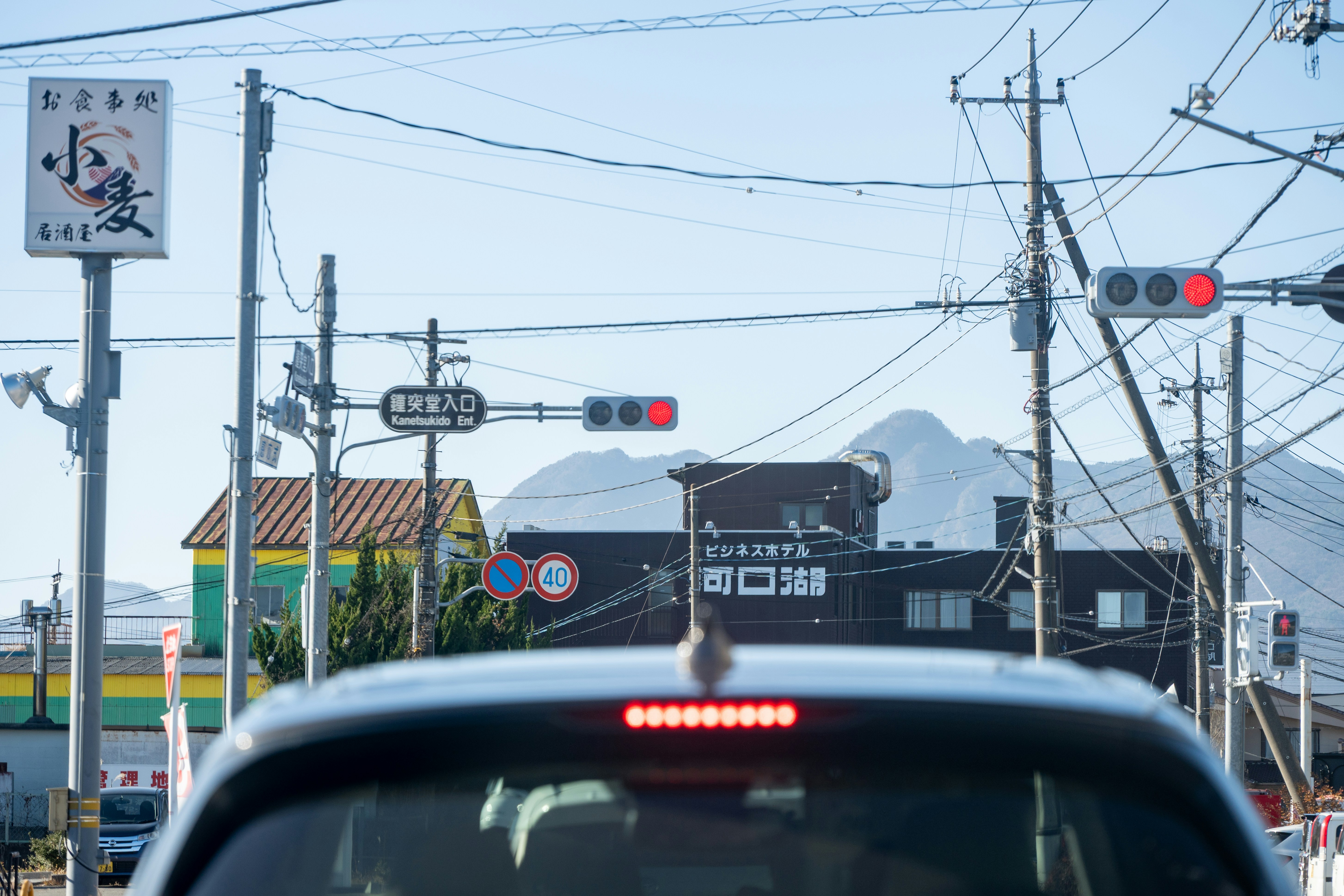 Rear-View Car at a Busy Street Crossing, Framed by Urban Telecommunication Lines