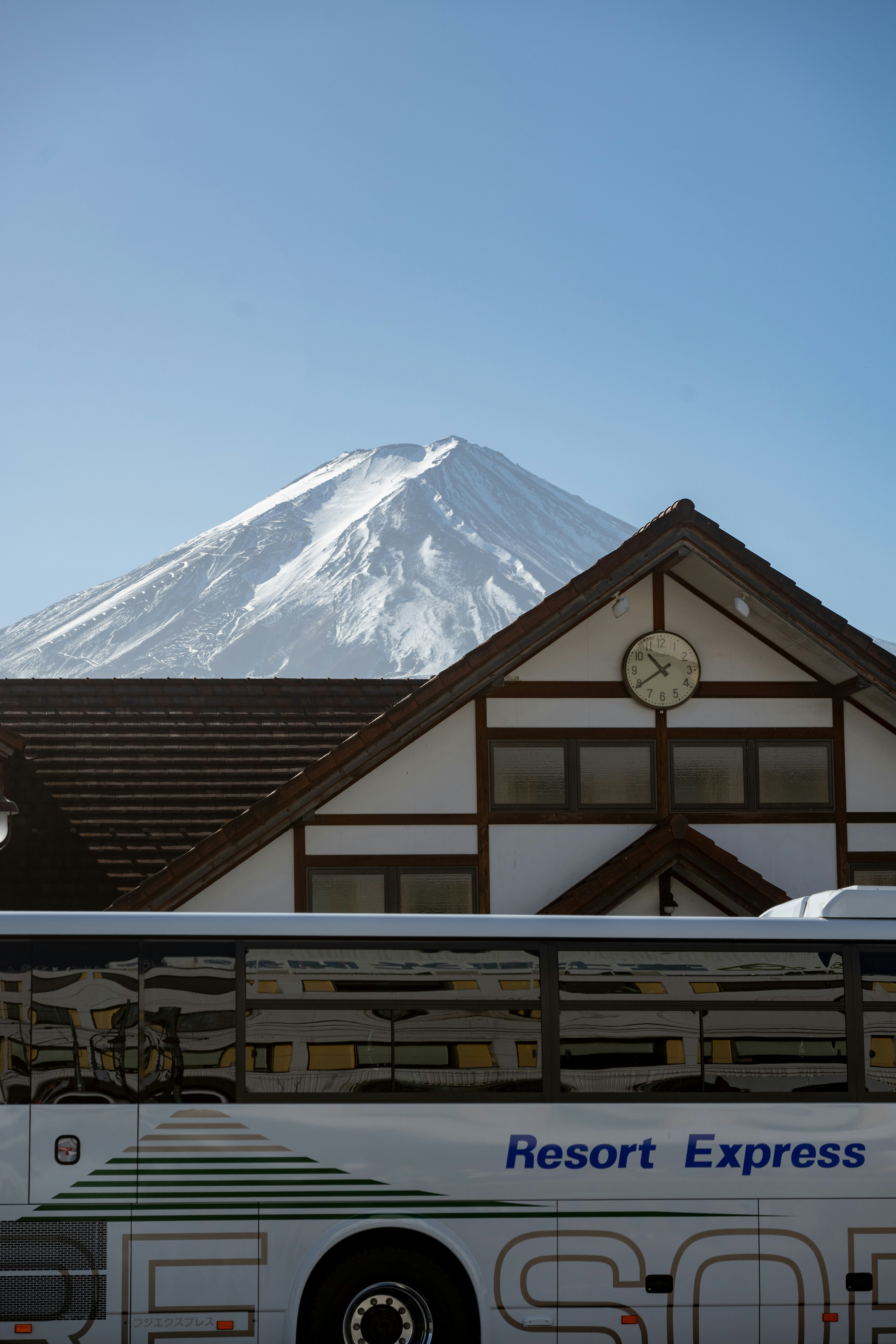 Snow-capped peak over alpine lodge and Resort Express bus