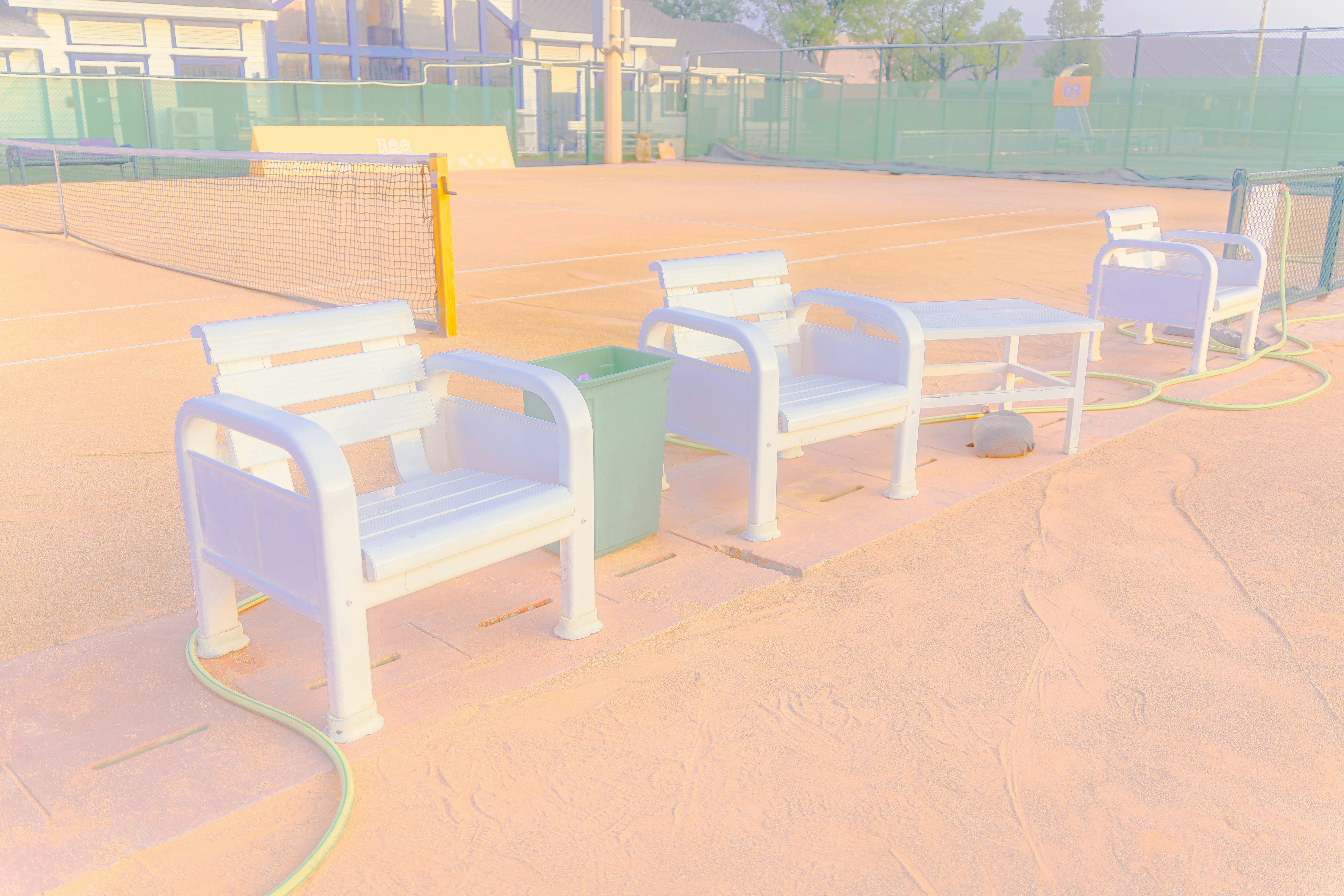 Sunlit Park Benches and Tennis Court in Dusk Hue
