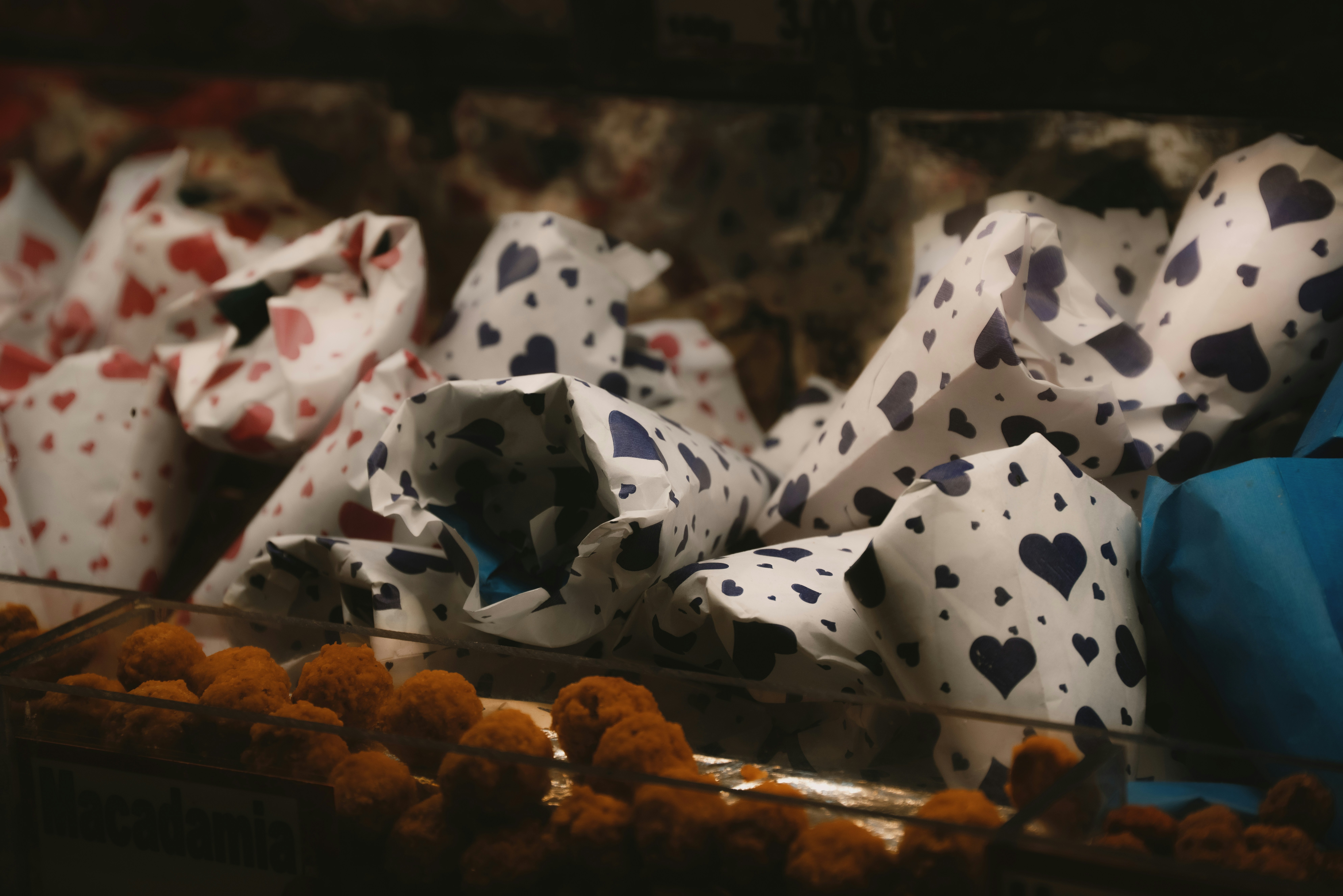 Masked array of cocoa-balled treats under dim shop lighting