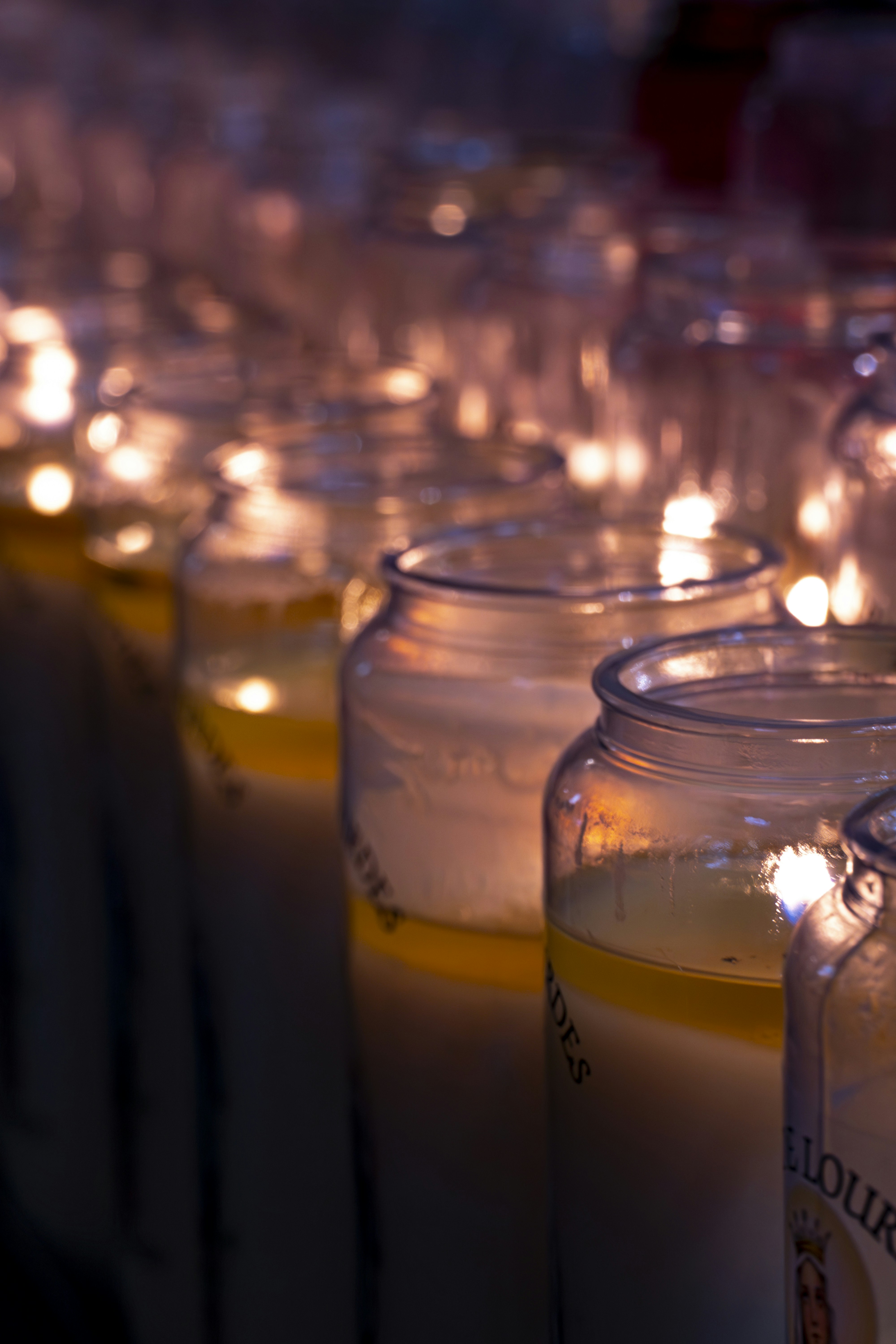 Warm Glimmer: A Row of Glass Jars Reflecting Soft Candlelight