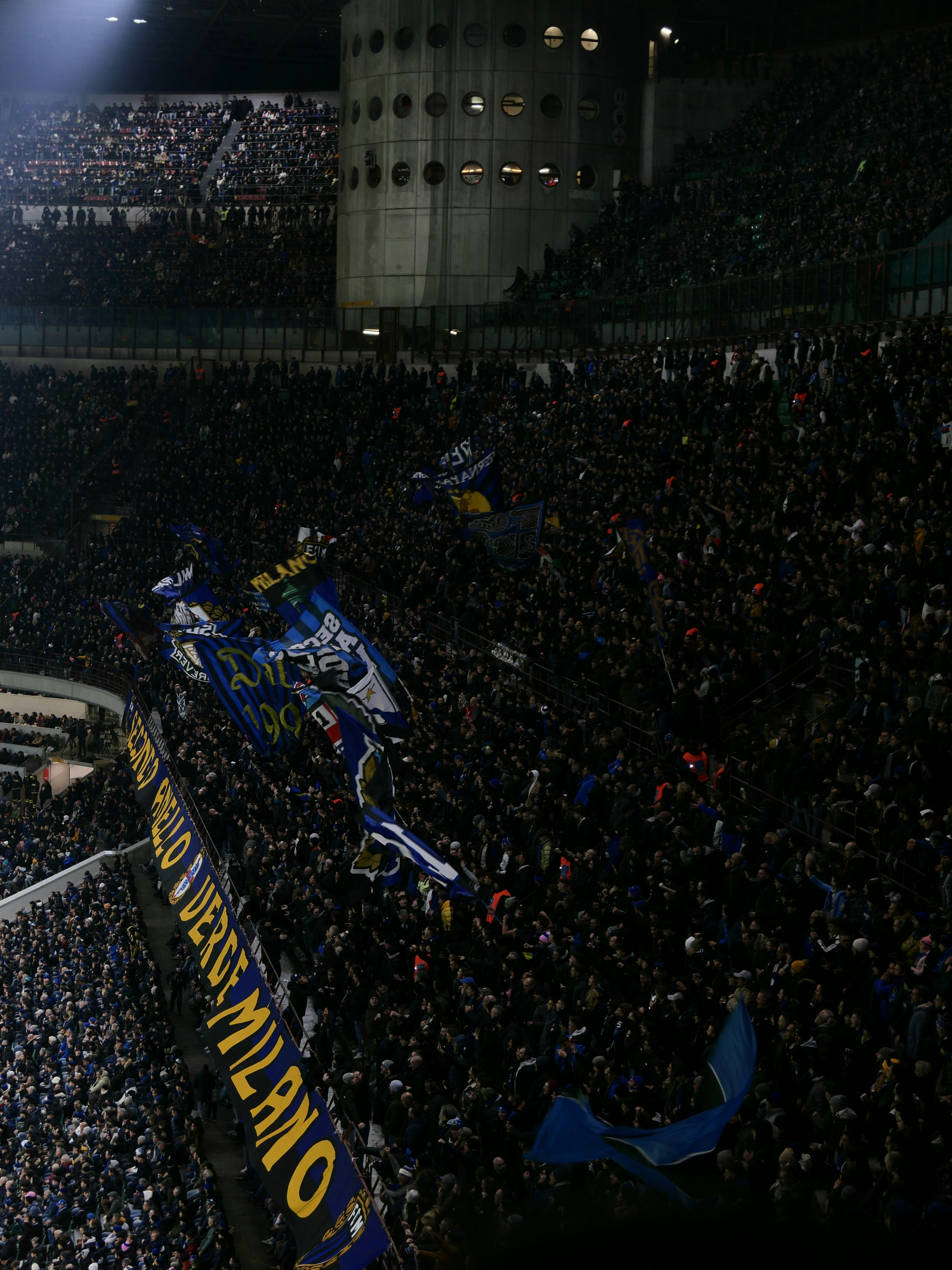 Crowd of fans with flags at a stadium at night