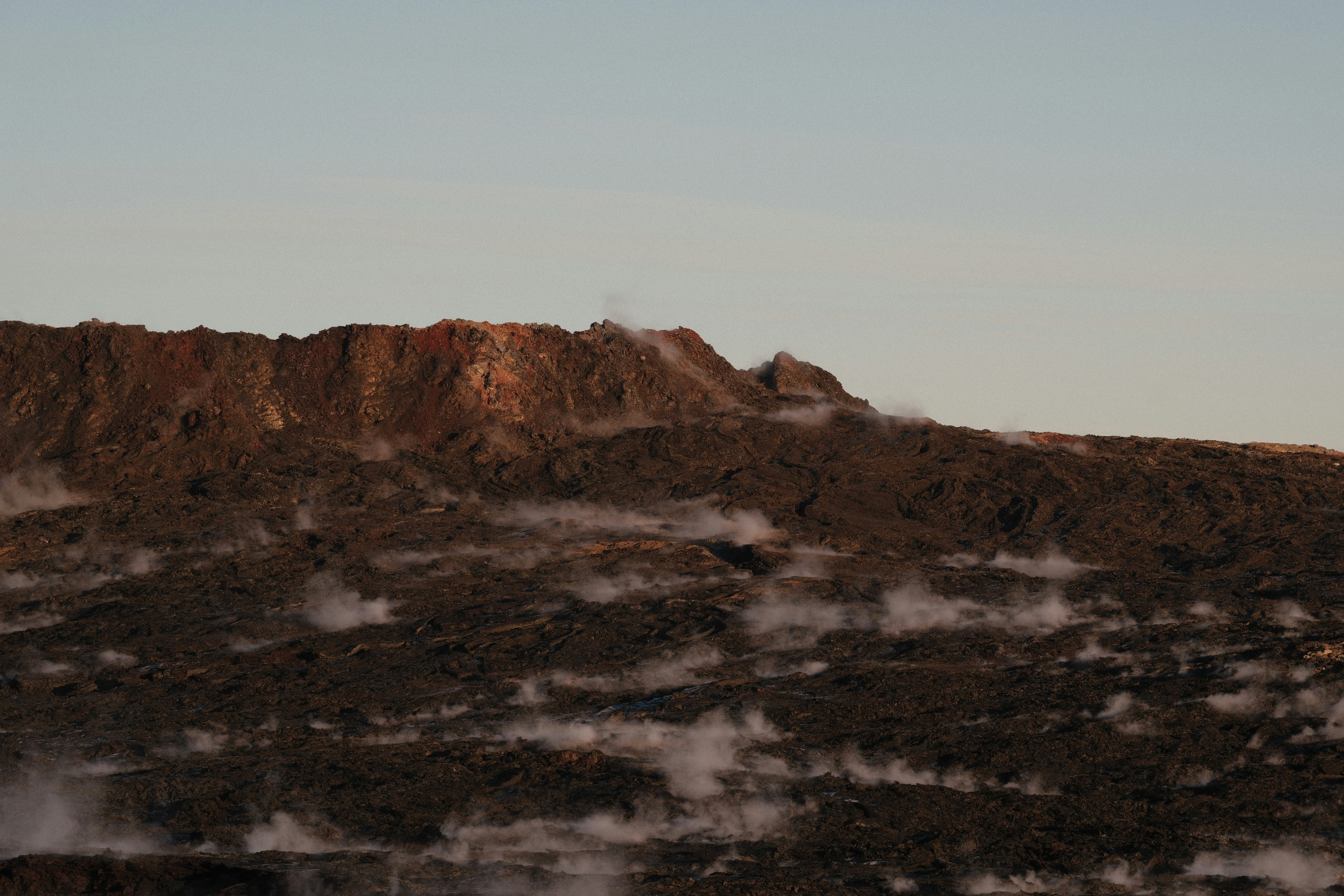 Walking over warm lava with a volcano in sight.