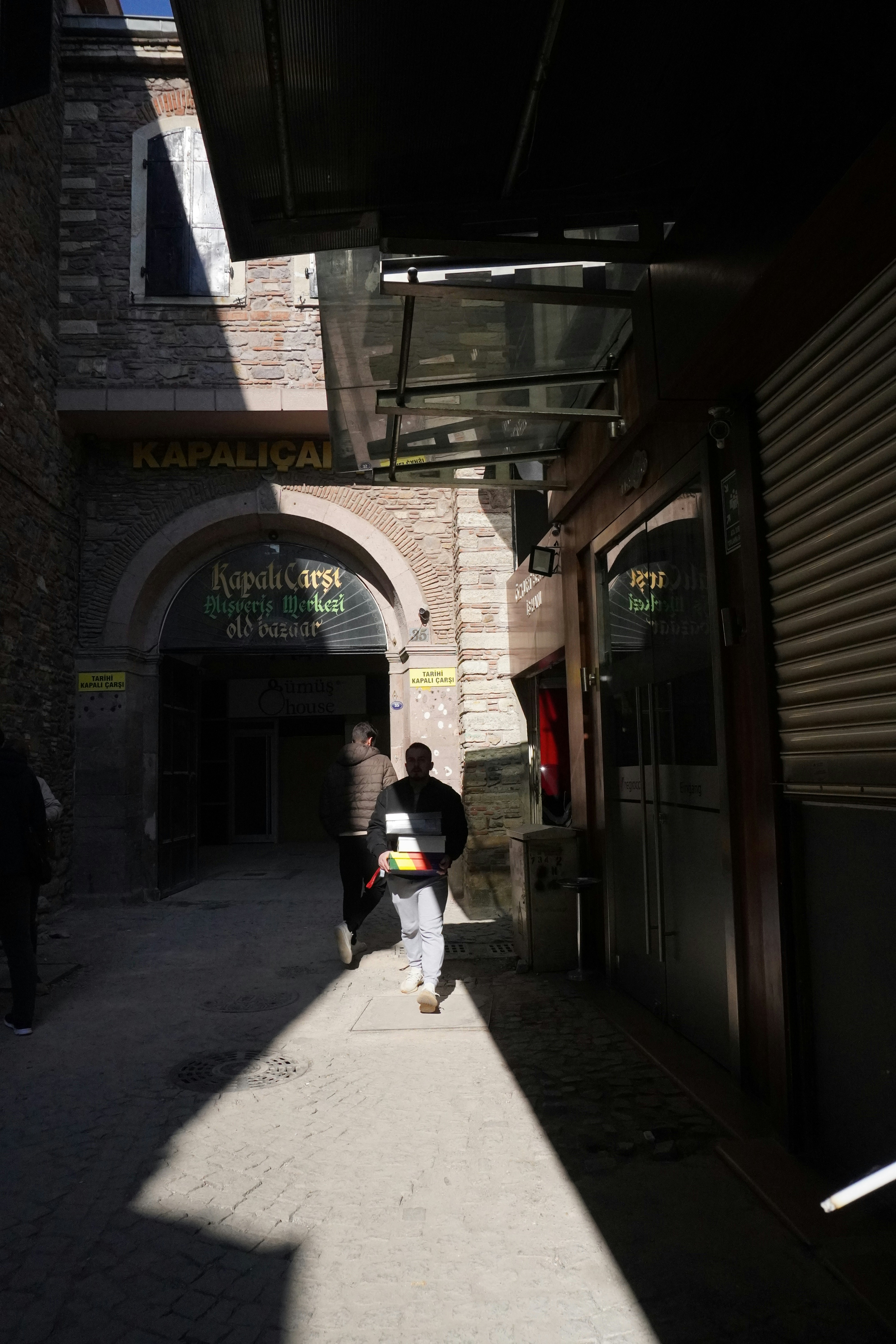 Sunlit Pedestrian Corridor Framed by Arched Entrance