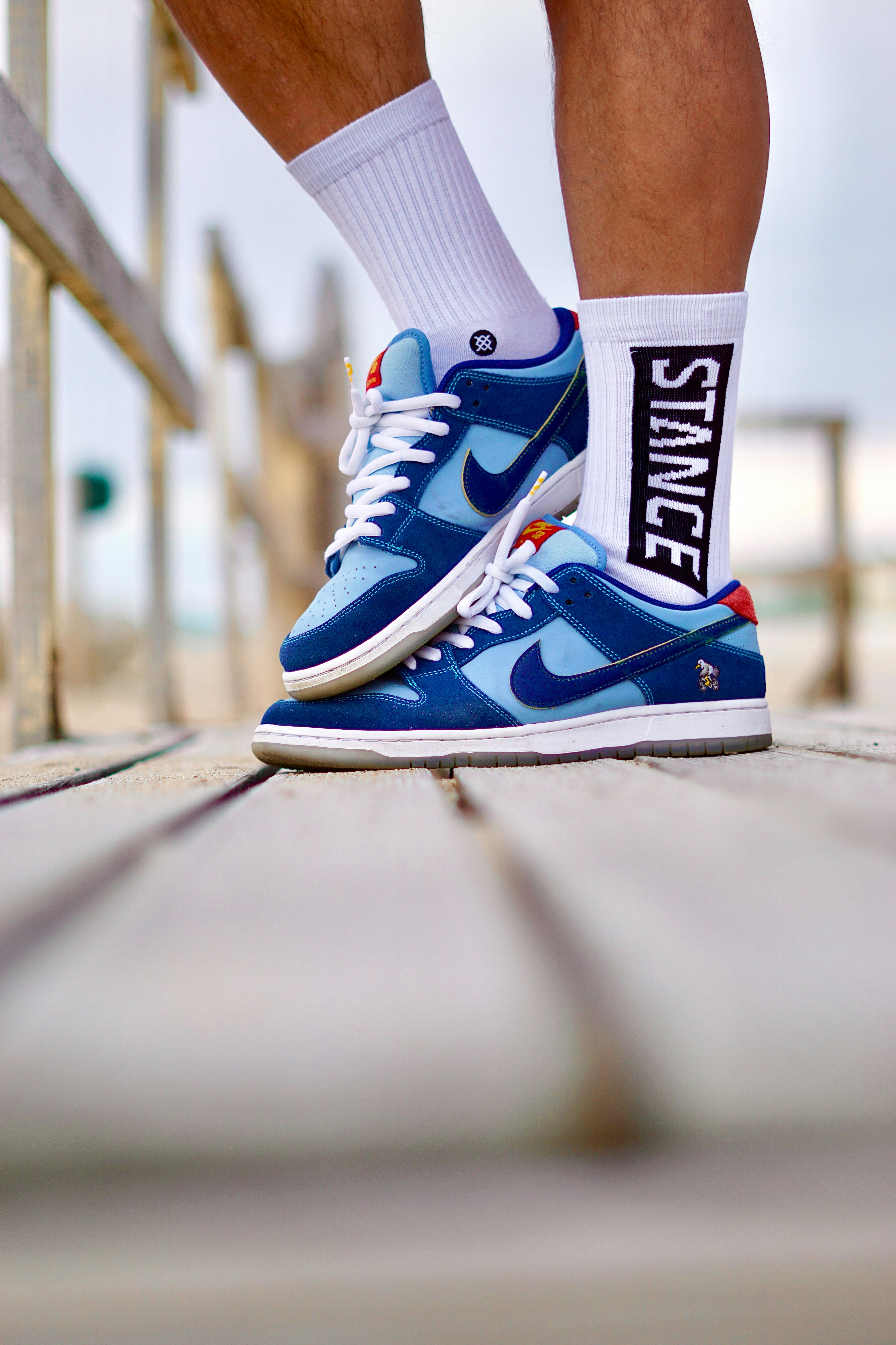 Blue playground: sneakers stacked on a wooden boardwalk