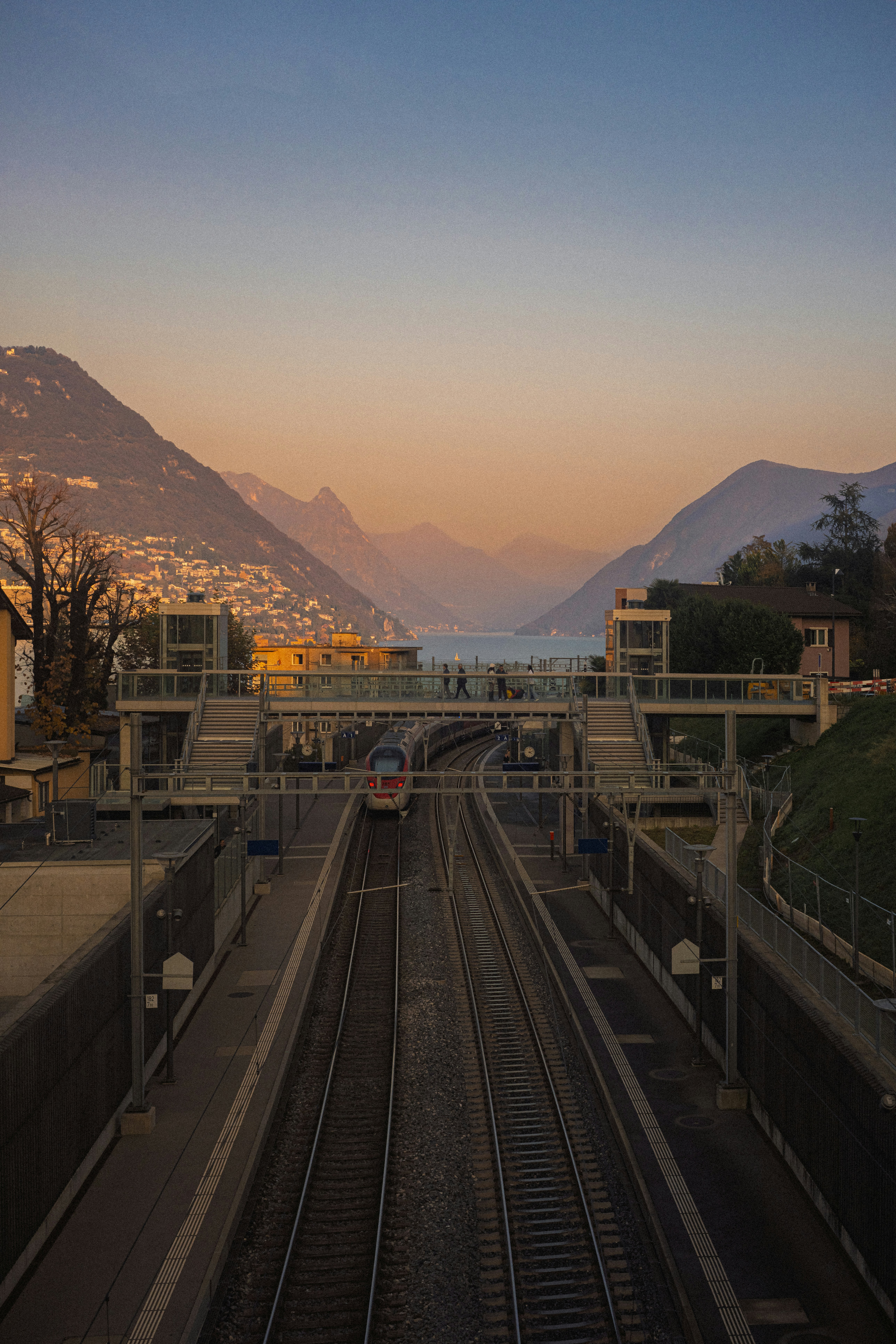 Tracks to the Lake: Sunset Echoes Over the Alpine Transit