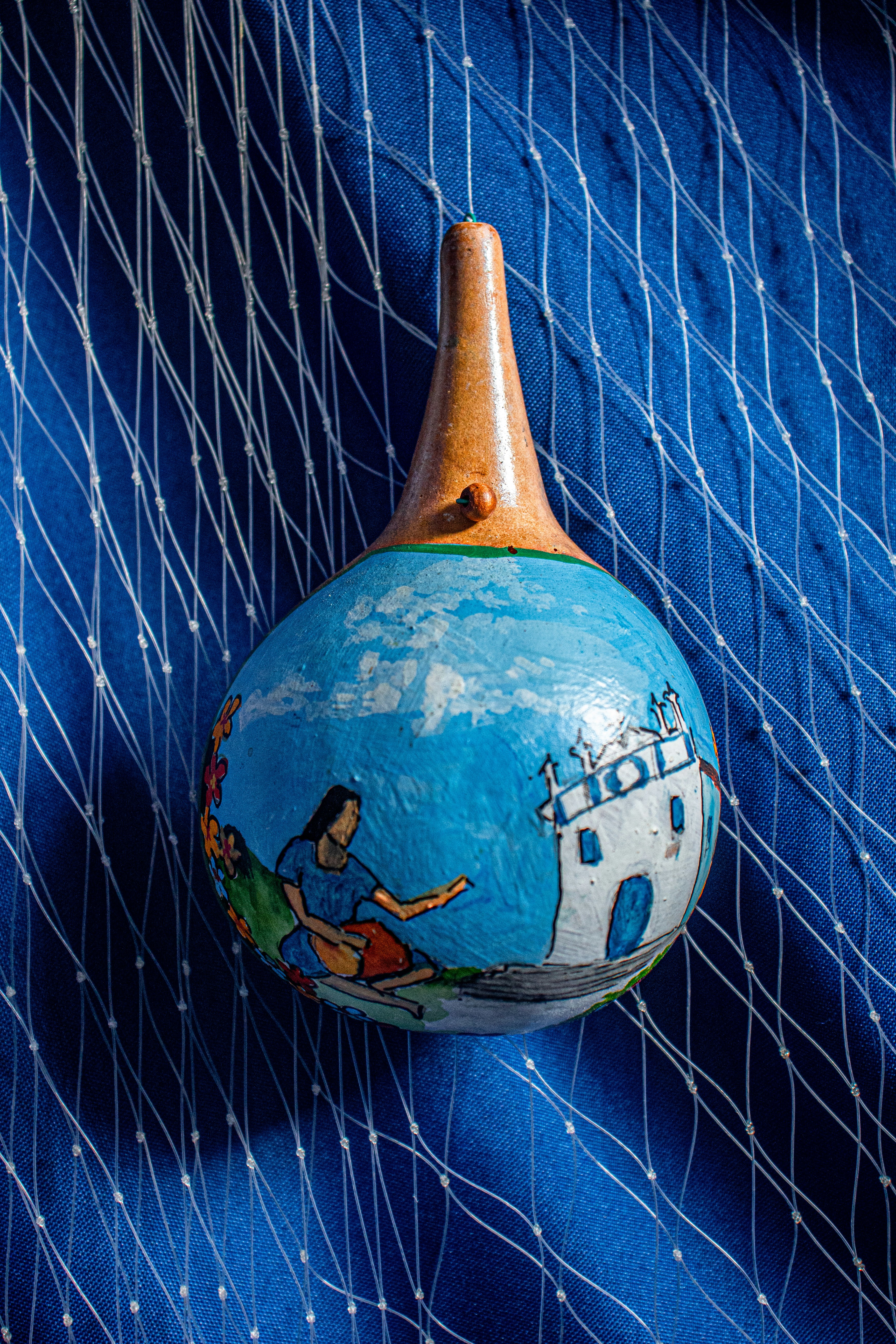 Blue-Tiled Sailor: A Painted Ornament Against Netted Backdrop