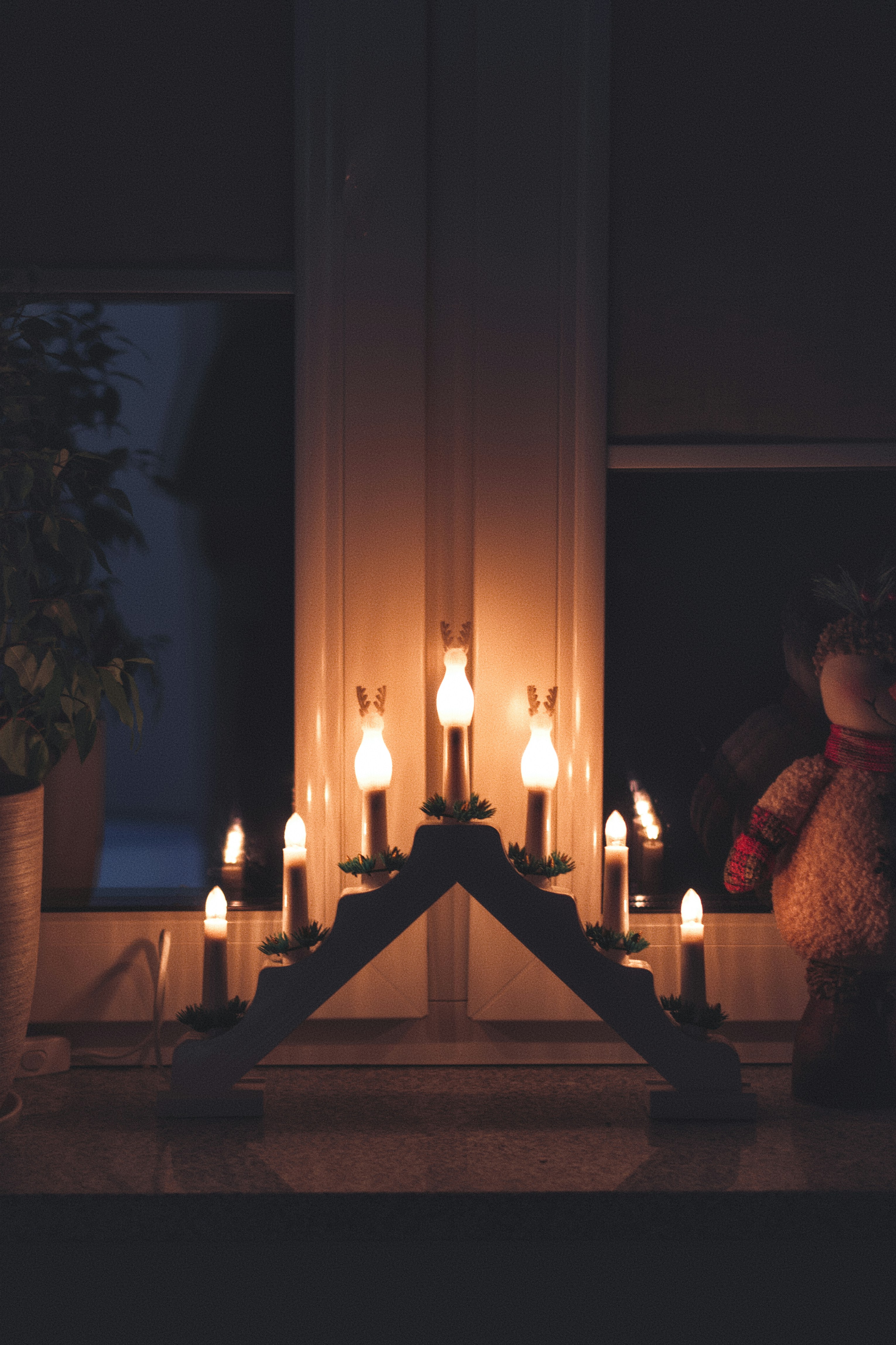 Candlelit centerpiece: warm glow framing a festive windowsill scene