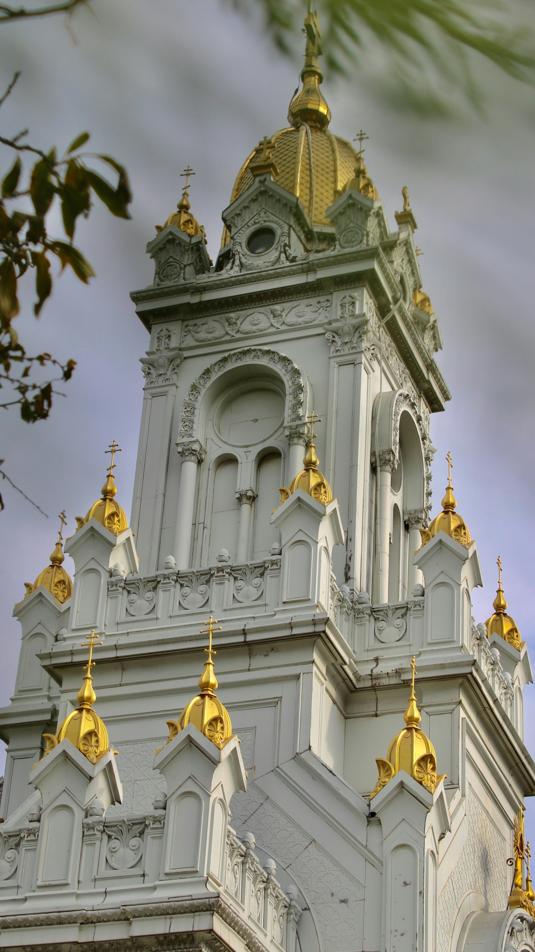 A stunning blend of white facades and golden domes, captured on a calm overcast day. The architecture feels almost ethereal, with intricate details and a serene atmosphere.
