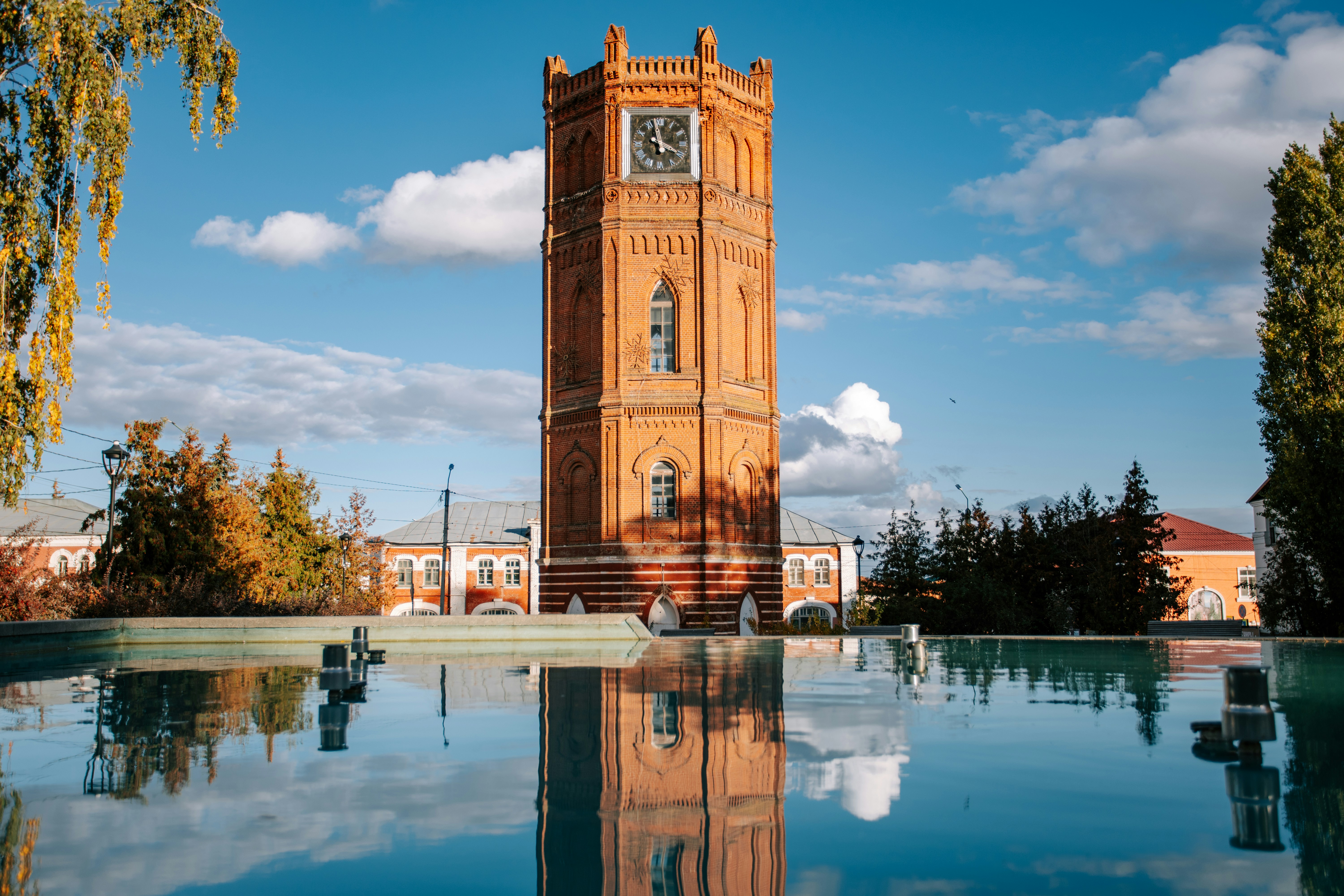 Brick Bell Tower Rising from a Calm Reflective Pool