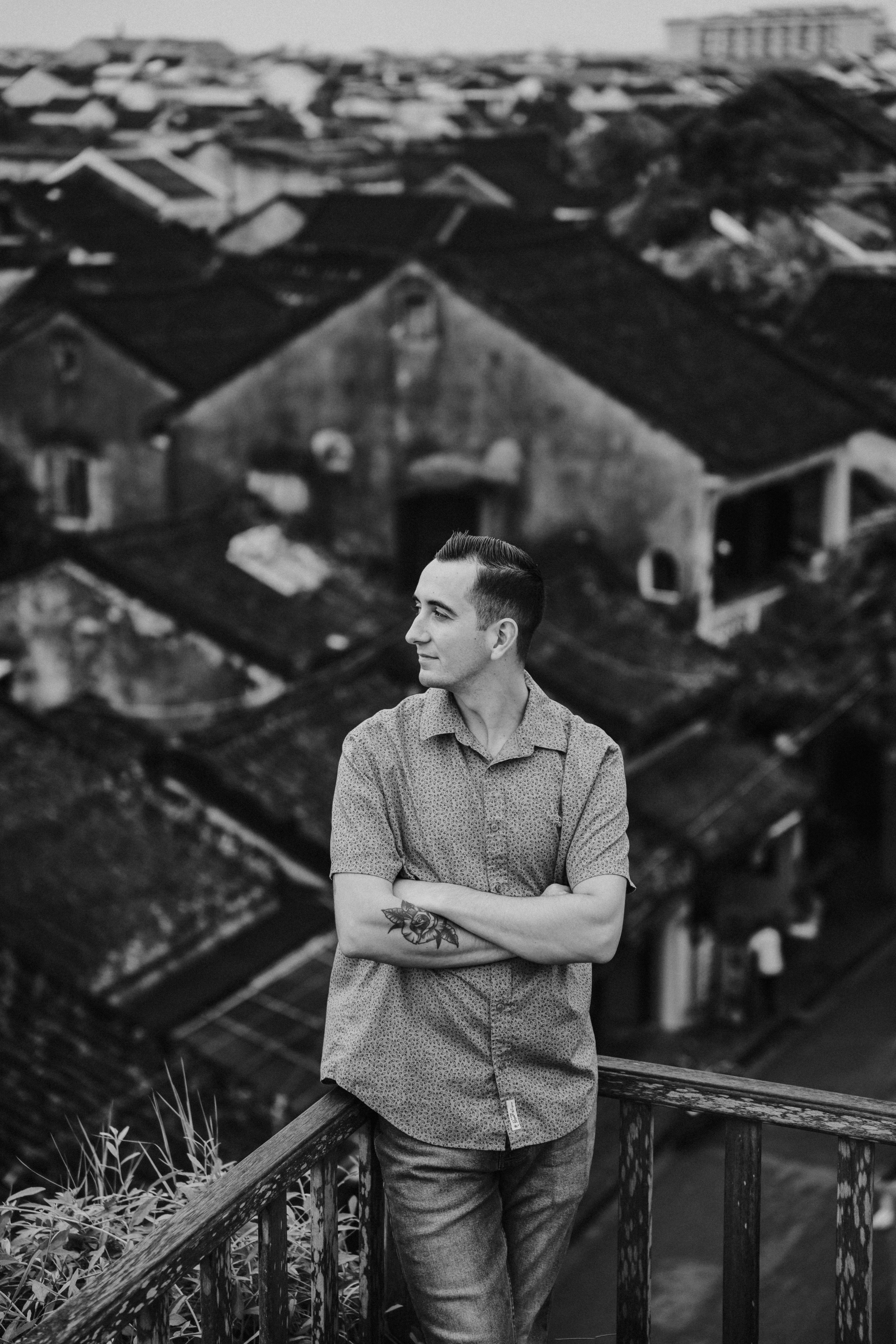 Man on a railing: quiet confidence against a tiled cityscape