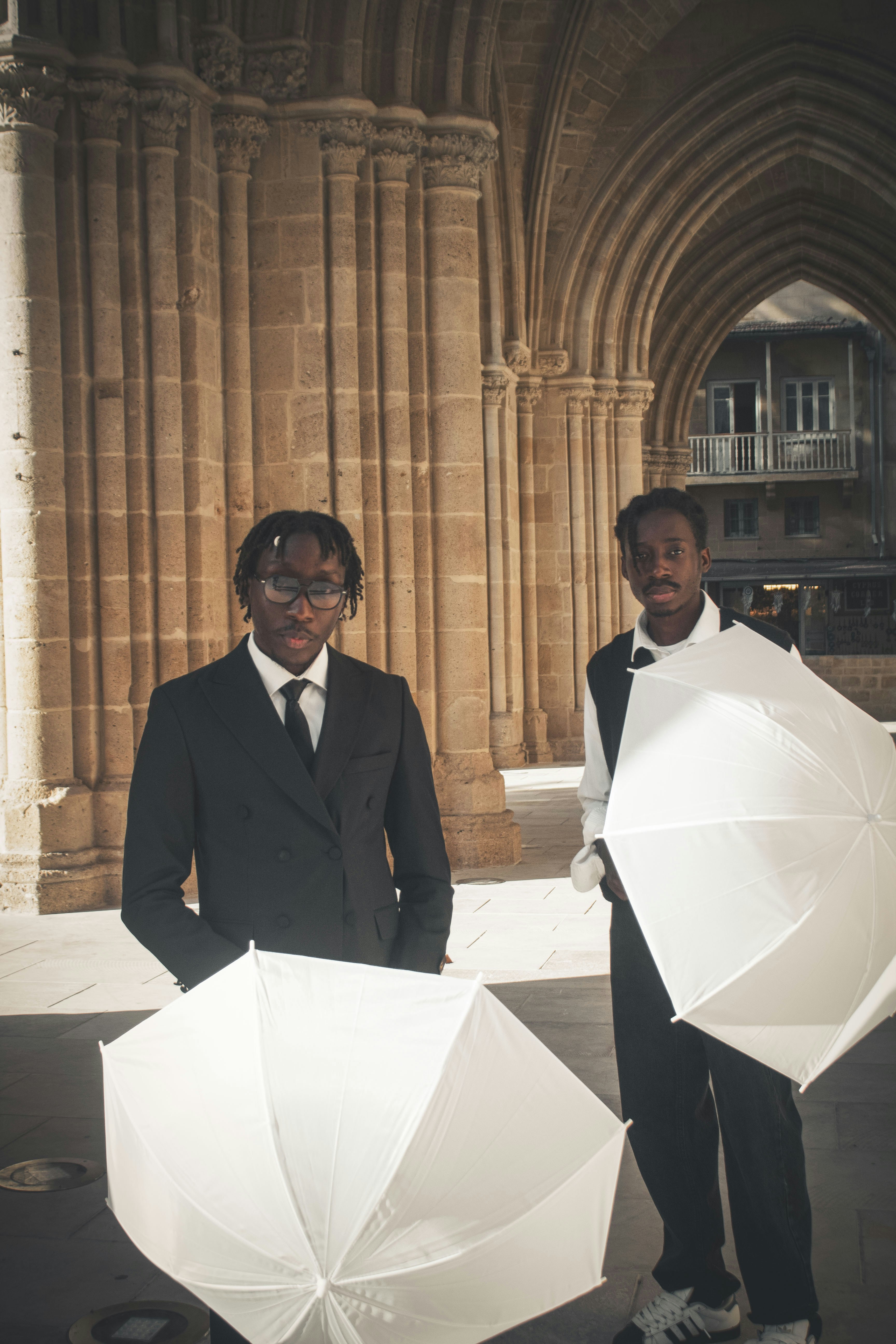 Diploma of Light: Two Gentlemen in Black Under Arch