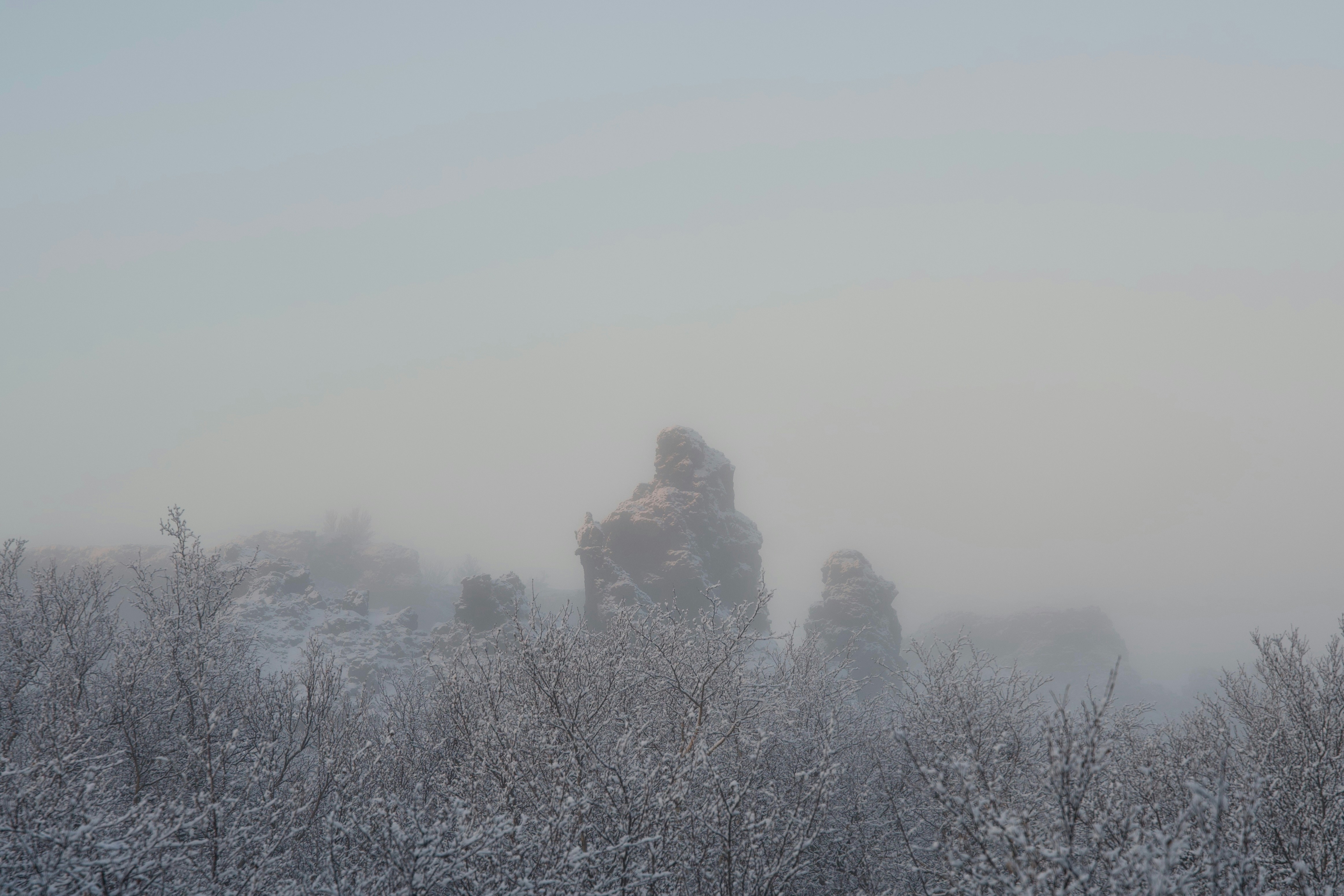 Mist Beyond the Frost: A Silhouette of Rock Formations in Winter Quiet