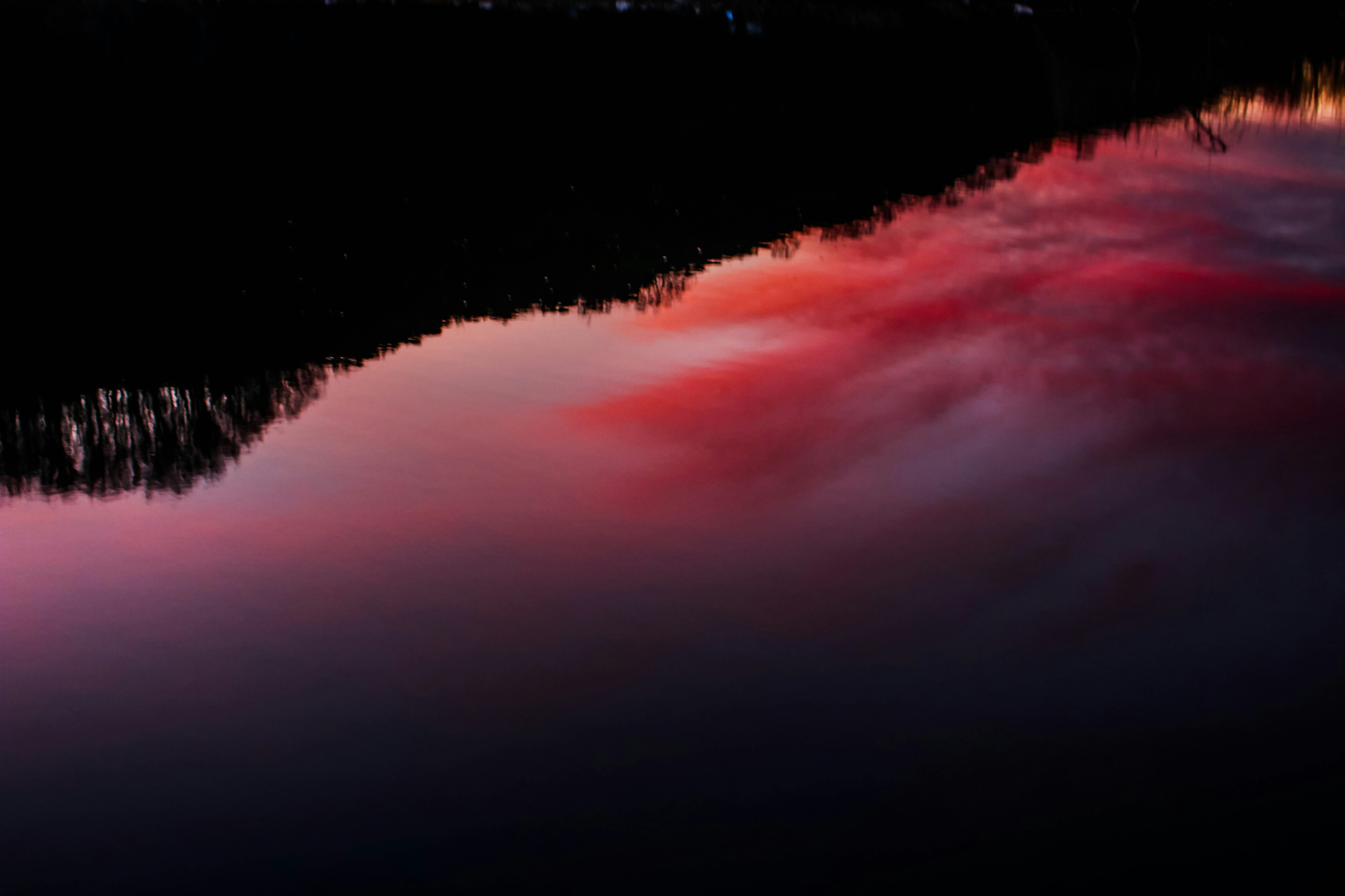 Abstract Red and Pink Sunrise Reflection on Dark Water