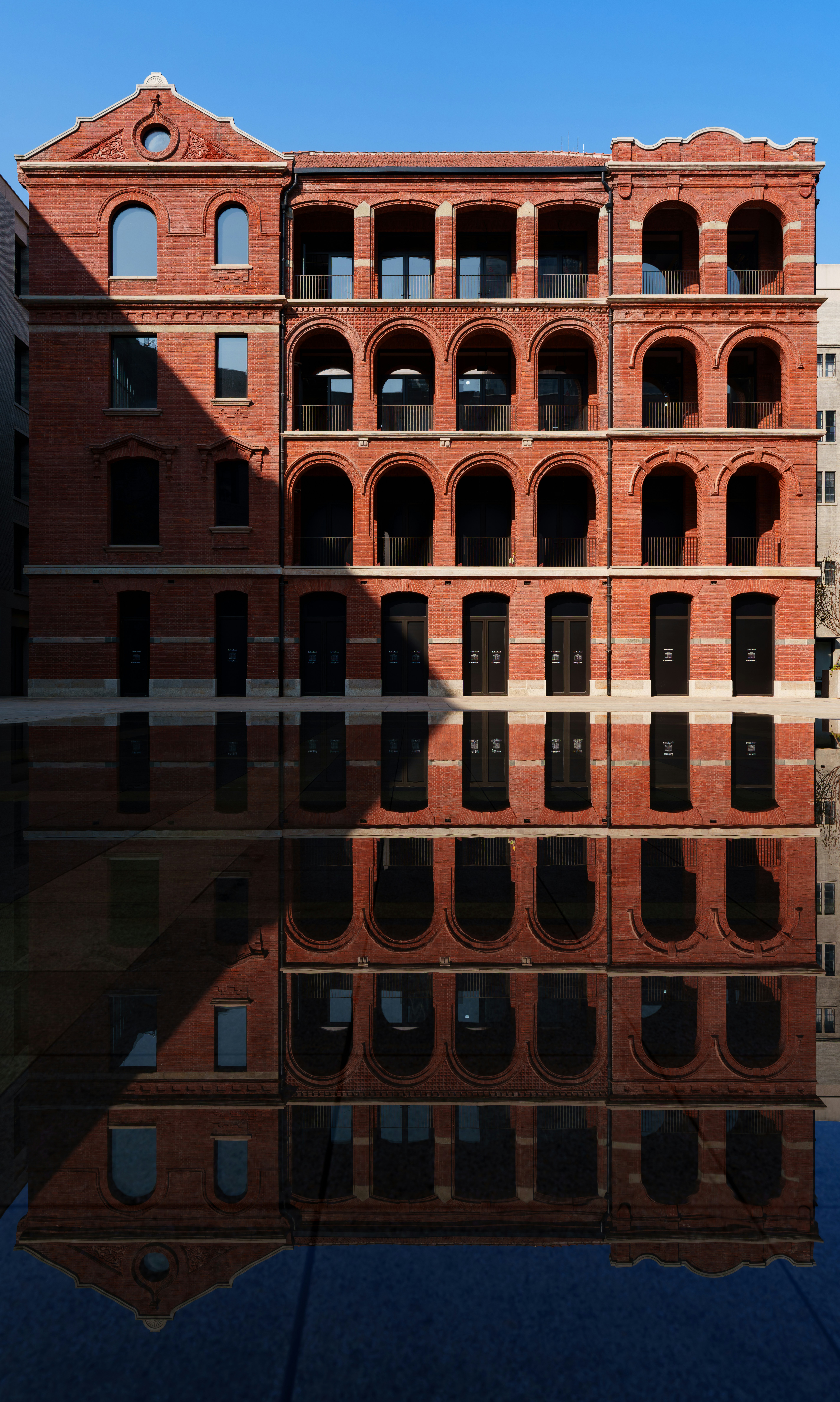 Reflected Red: A Brick Factory Rises in Symmetrical Echoes