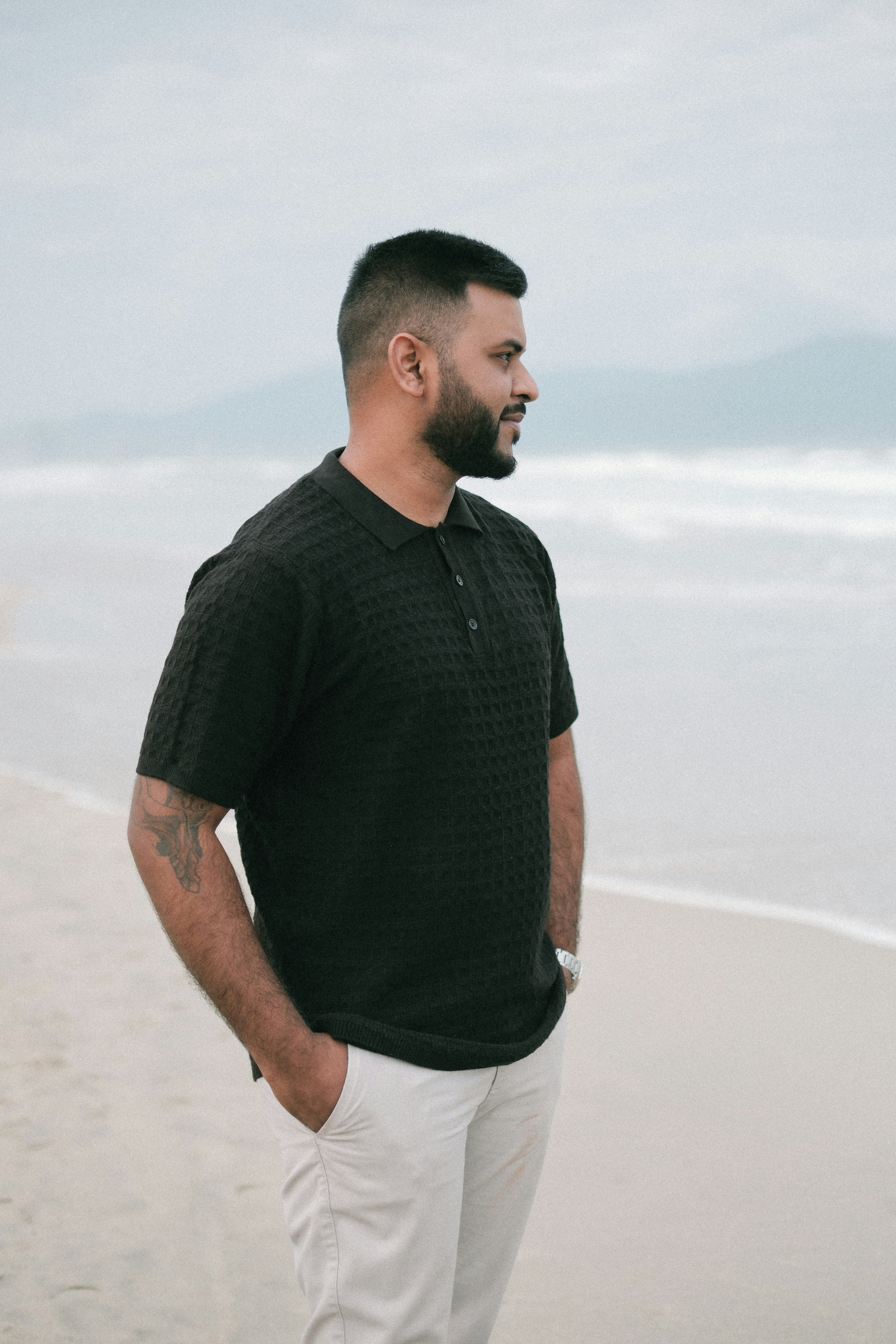 Coastal Confidence: A Man in Black Polo at the Shore