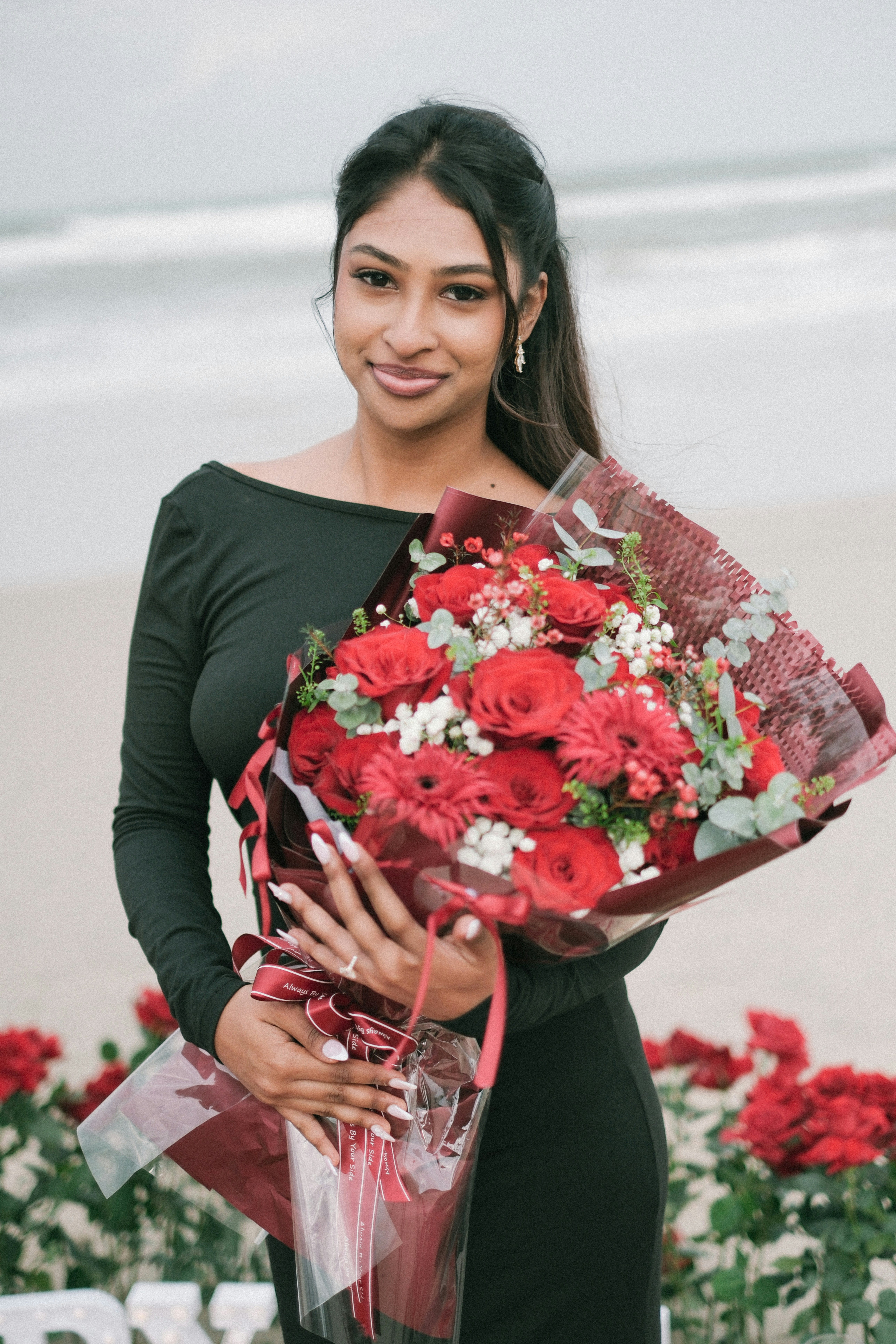 Woman holding a large bouquet of red roses
