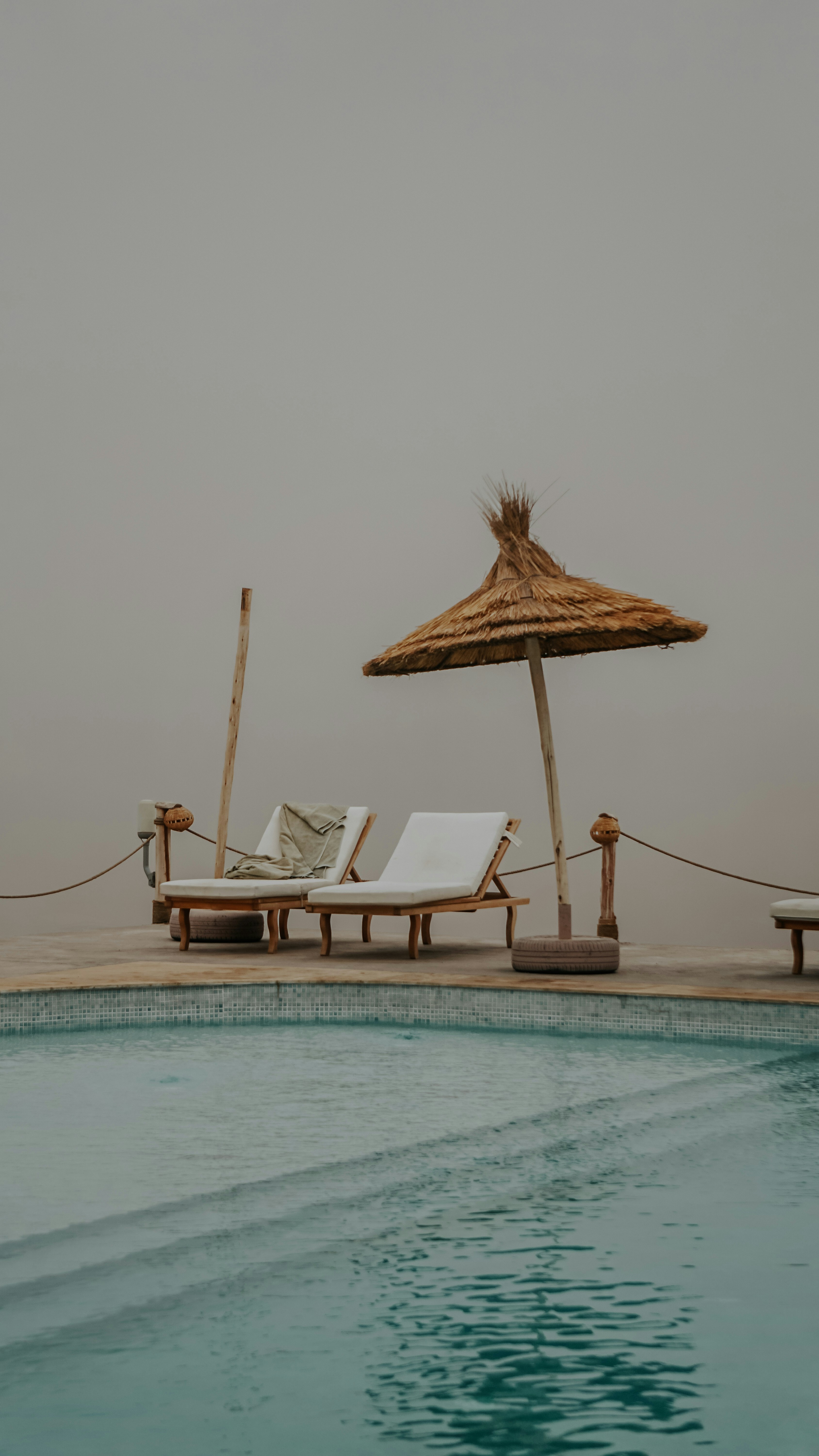 Lounge by the Lagoon: Sunbeds Beneath a Straw Umbrella
