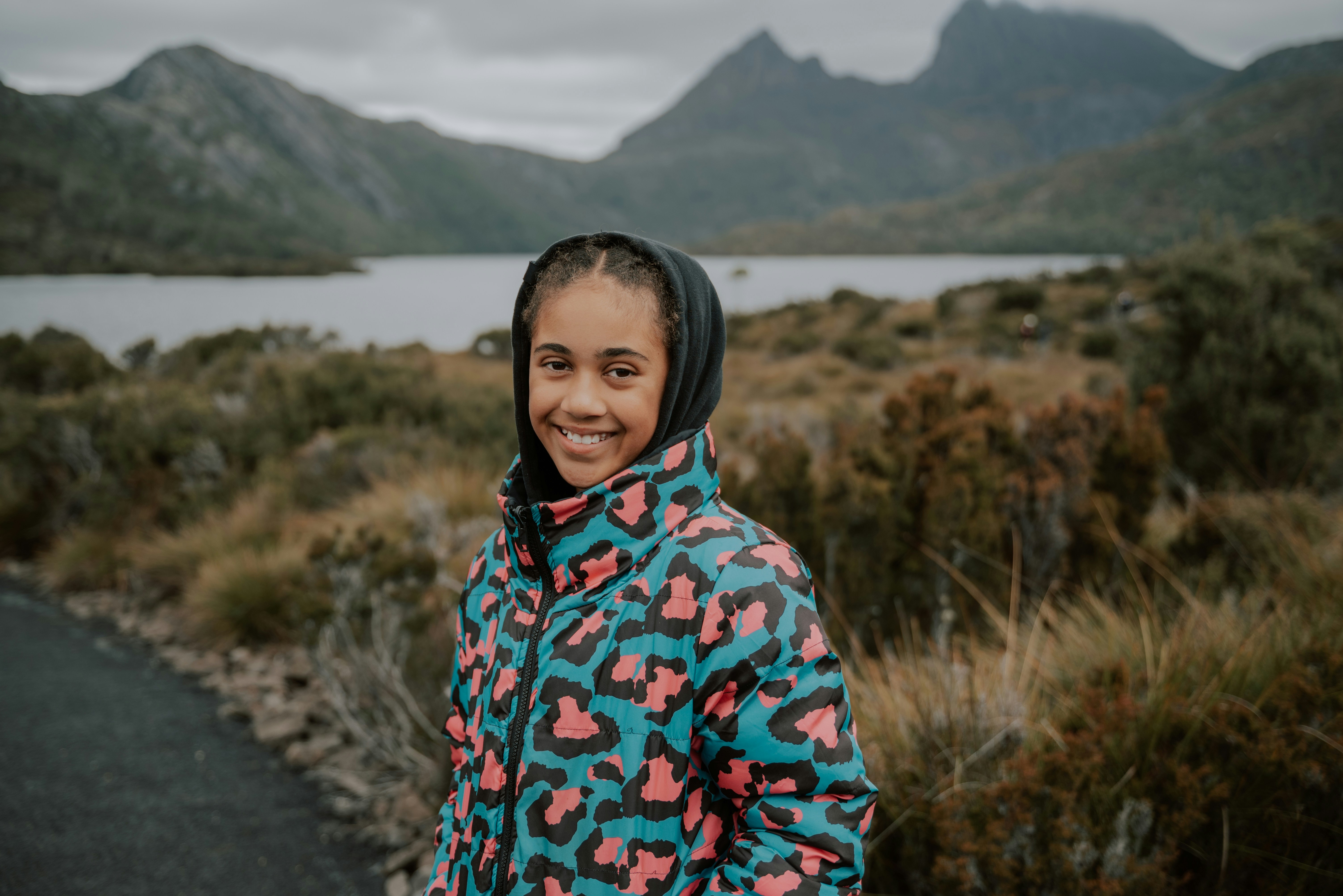 Portrait on the Path: A hopeful smile against rugged highland scenery