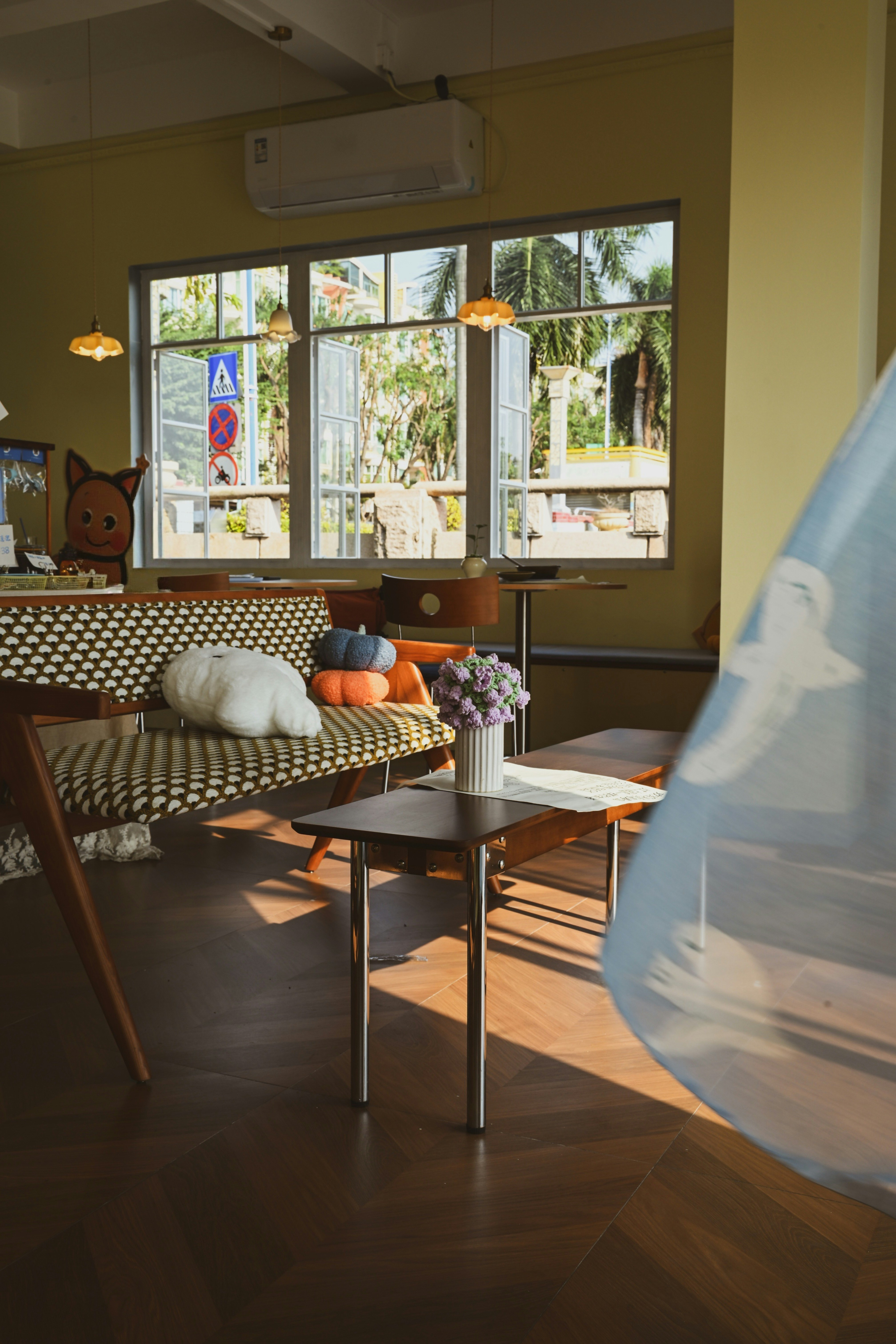 Sunlit Café Lounge with Plush Pumpkins and a Flowing Flag
