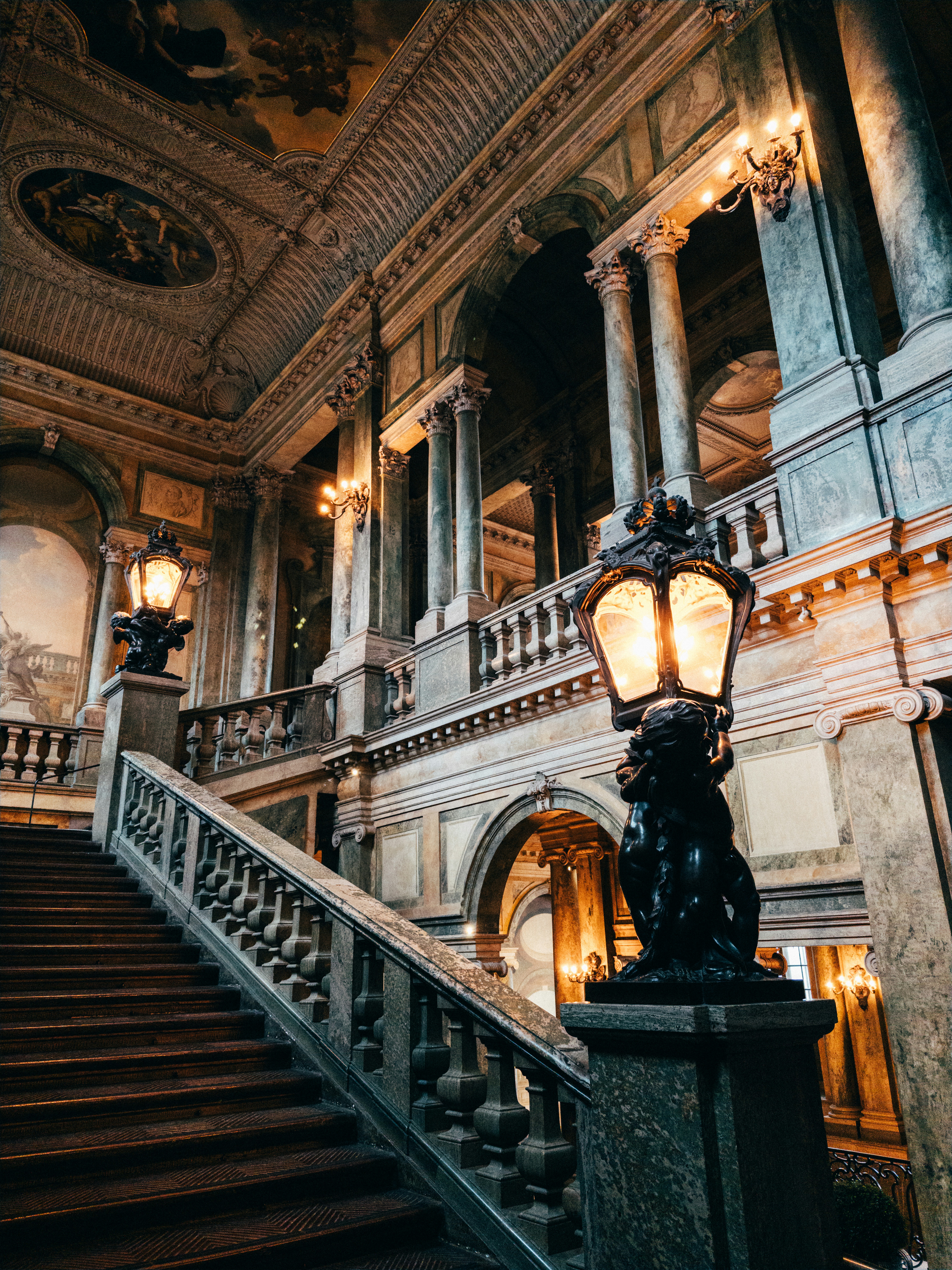 Ornate staircase with antique lamps in grand building