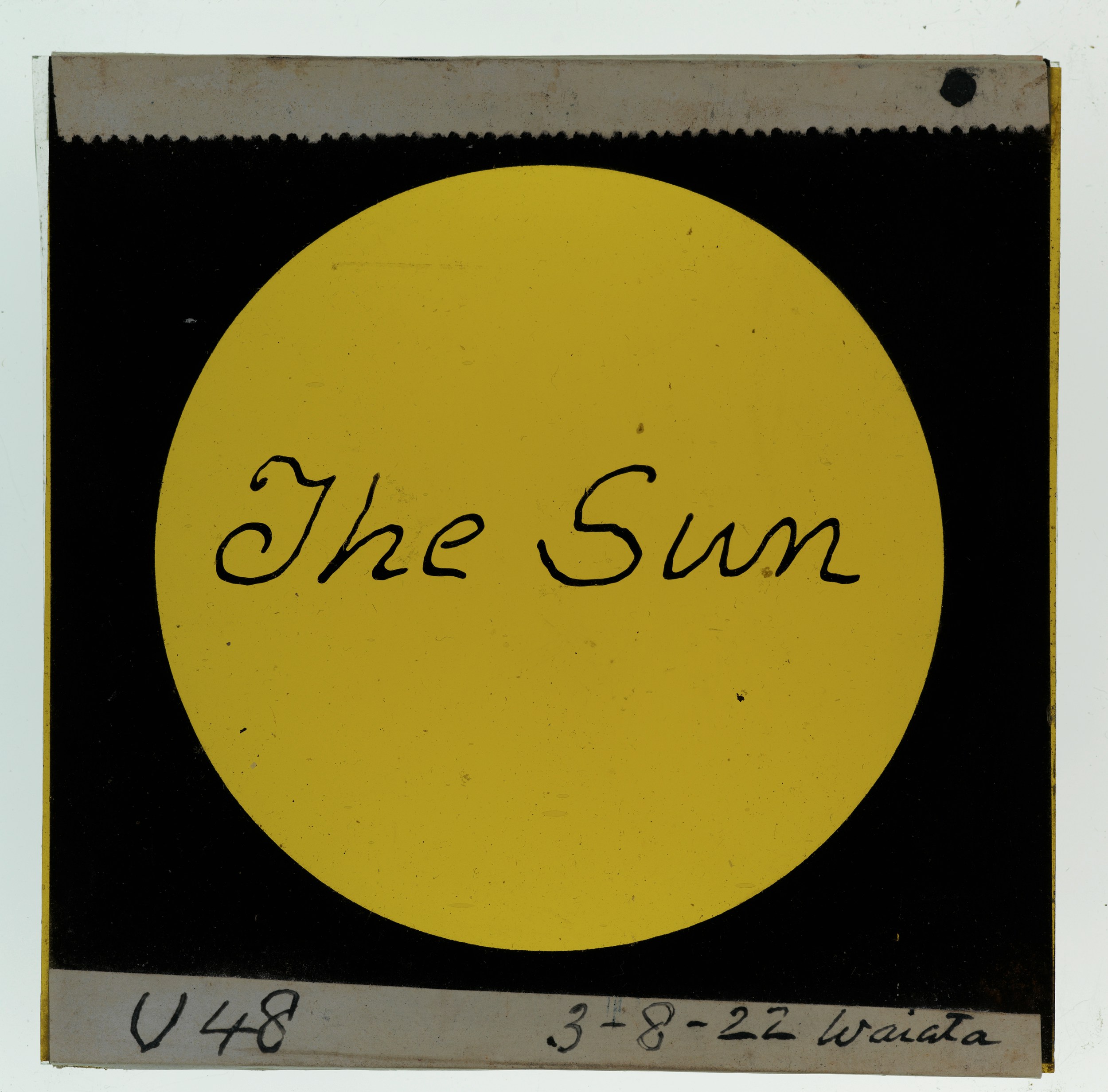A lantern slide produced by Clement Lindley Wragge (b.1852, d.1922), likely dating between 1890-1922. This lantern slide is red tinted plate depicting surface of the moon. Details of a large crater (Euler) can be seen, with smaller craters, ridges and other lunar features in the vicinity. Shared by Auckland War Memorial Museum, Tāmaki Paenga Hira, as part of the Clement Lindley Wragge collection
