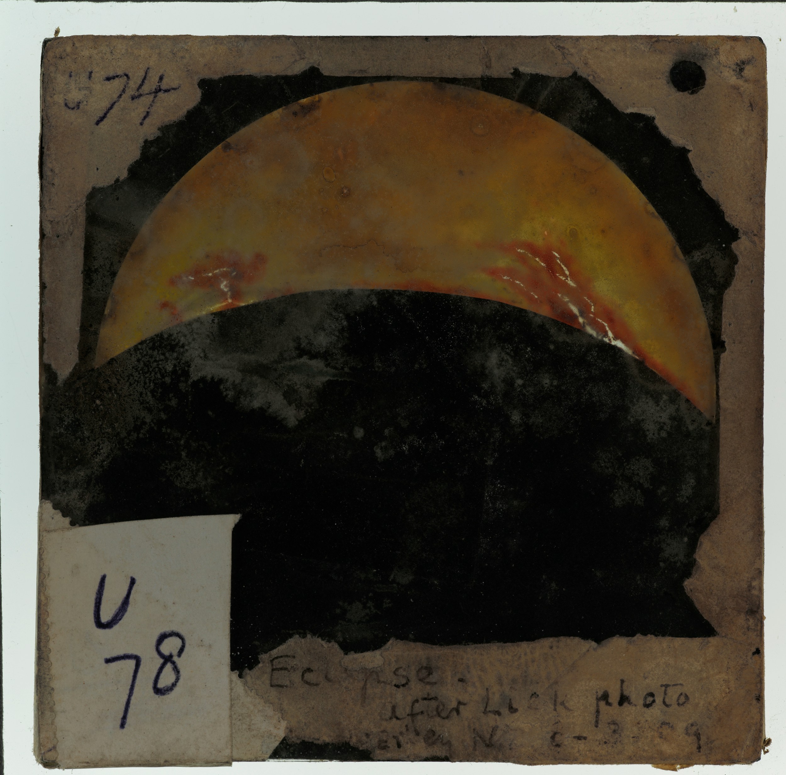 A lantern slide produced by Clement Lindley Wragge (b.1852, d.1922), dated 8 March 1909. The slide shows an image of a solar eclipse. The Sun is represented by a yellow/orange crescent with red/white cracks across surface. Placed across the lower section of the sun is a dark semi circle, representative of the moon. Shared by Auckland War Memorial Museum, Tāmaki Paenga Hira, as part of the Clement Lindley Wragge collection
