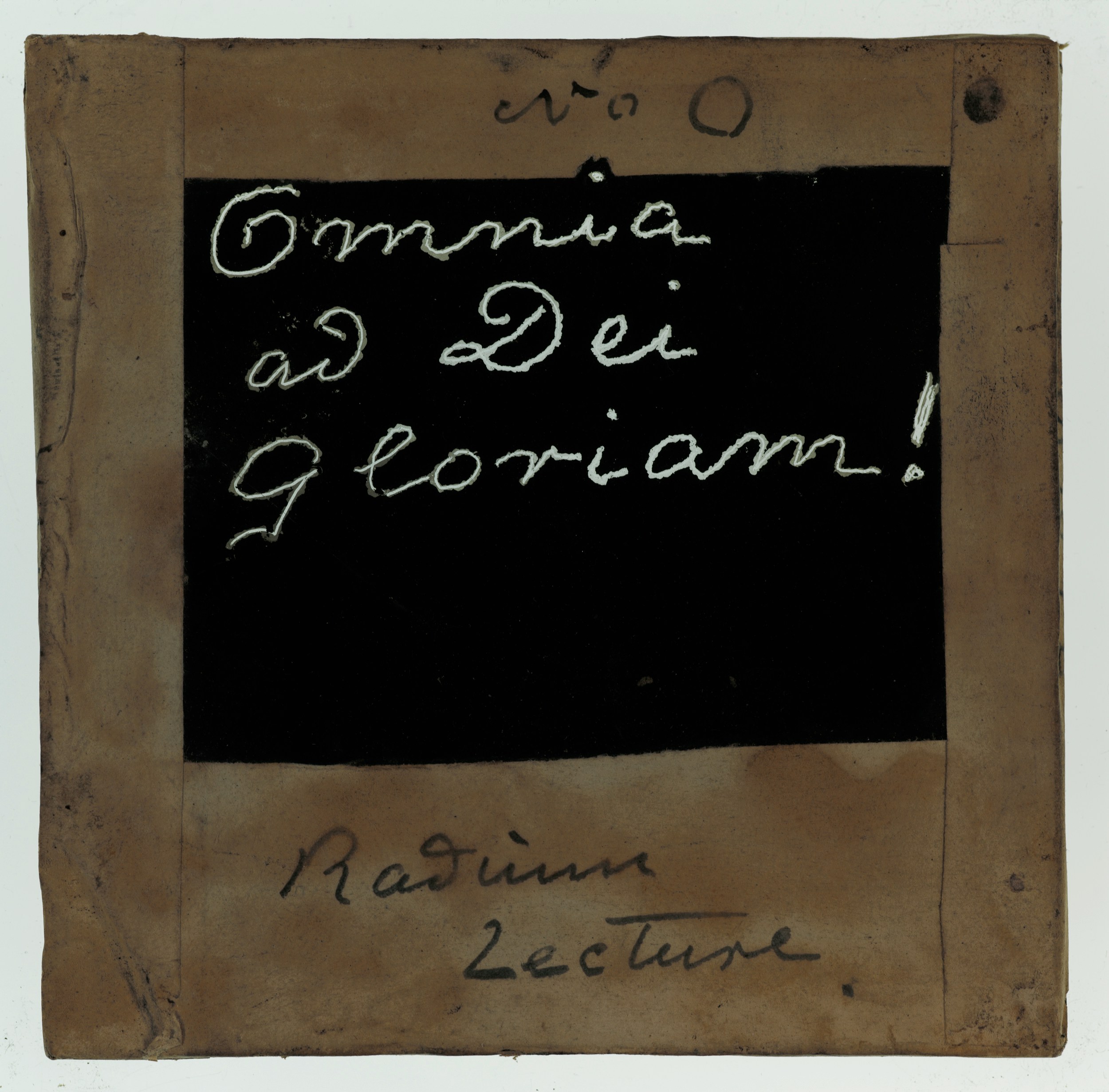 A lantern slide produced by Clement Lindley Wragge (b.1852, d.1922), likely dating between 1890-1922. The slide shows text on plate, reading 'Omnia ad Dei Gloriam!' [All Glory to God!]. Shared by Auckland War Memorial Museum, Tāmaki Paenga Hira, as part of the Clement Lindley Wragge collection. 236007|PH-1984-1-LS78-3-132|0. No known copyright restrictions. https://www.aucklandmuseum.com/discover/collections/record/1033209
