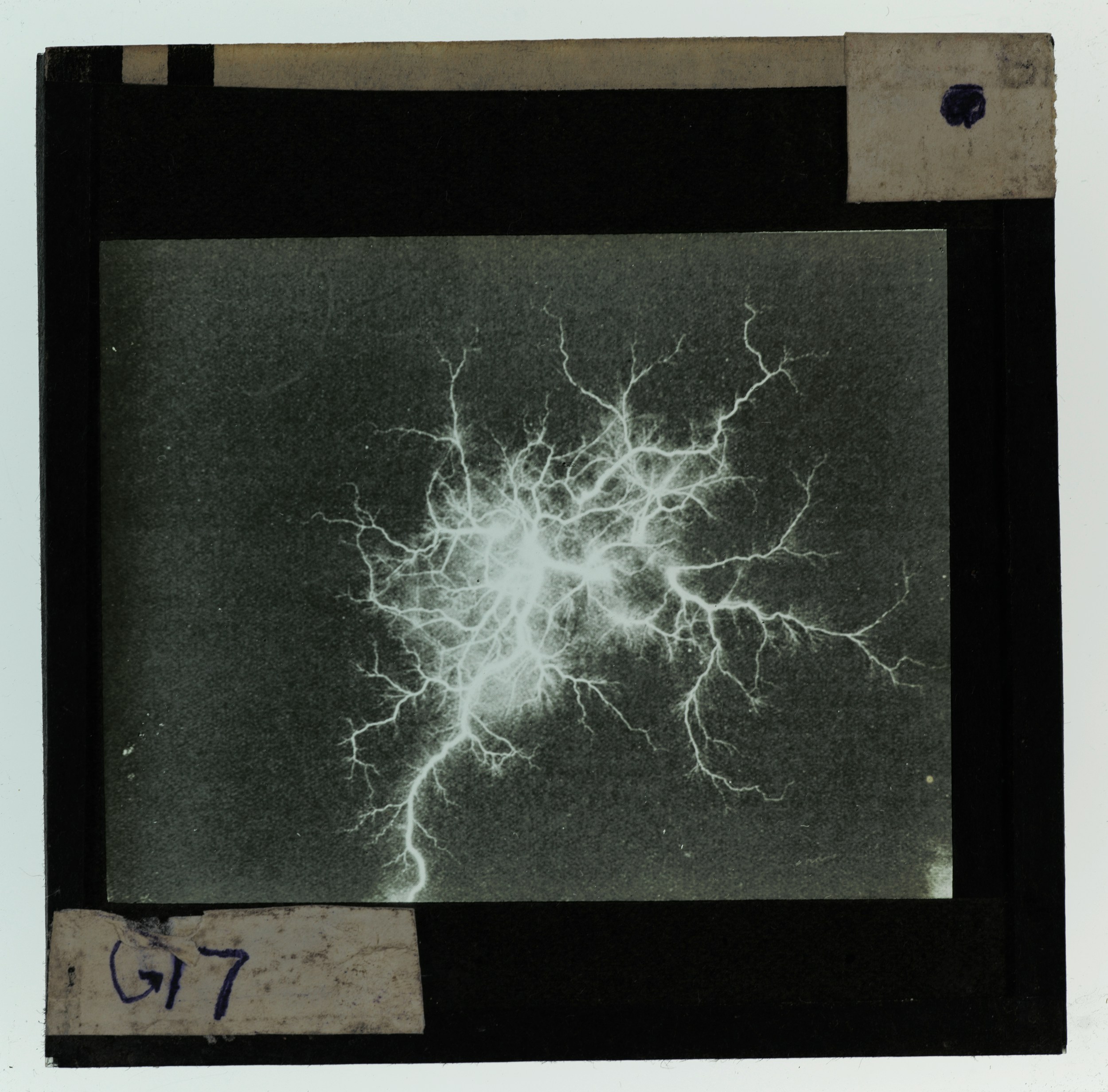 A lantern slide produced by Clement Lindley Wragge (b.1852, d.1922), likely dating between 1890-1922. The slide shows a cluster of electrical energy with radiating lighting strikes against a black background. Shared by Auckland War Memorial Museum, Tāmaki Paenga Hira, as part of the Clement Lindley Wragge collection. 235964|PH-1984-1-LS78-3-35|17. No known copyright restrictions. https://www.aucklandmuseum.com/discover/collections/record/1033251