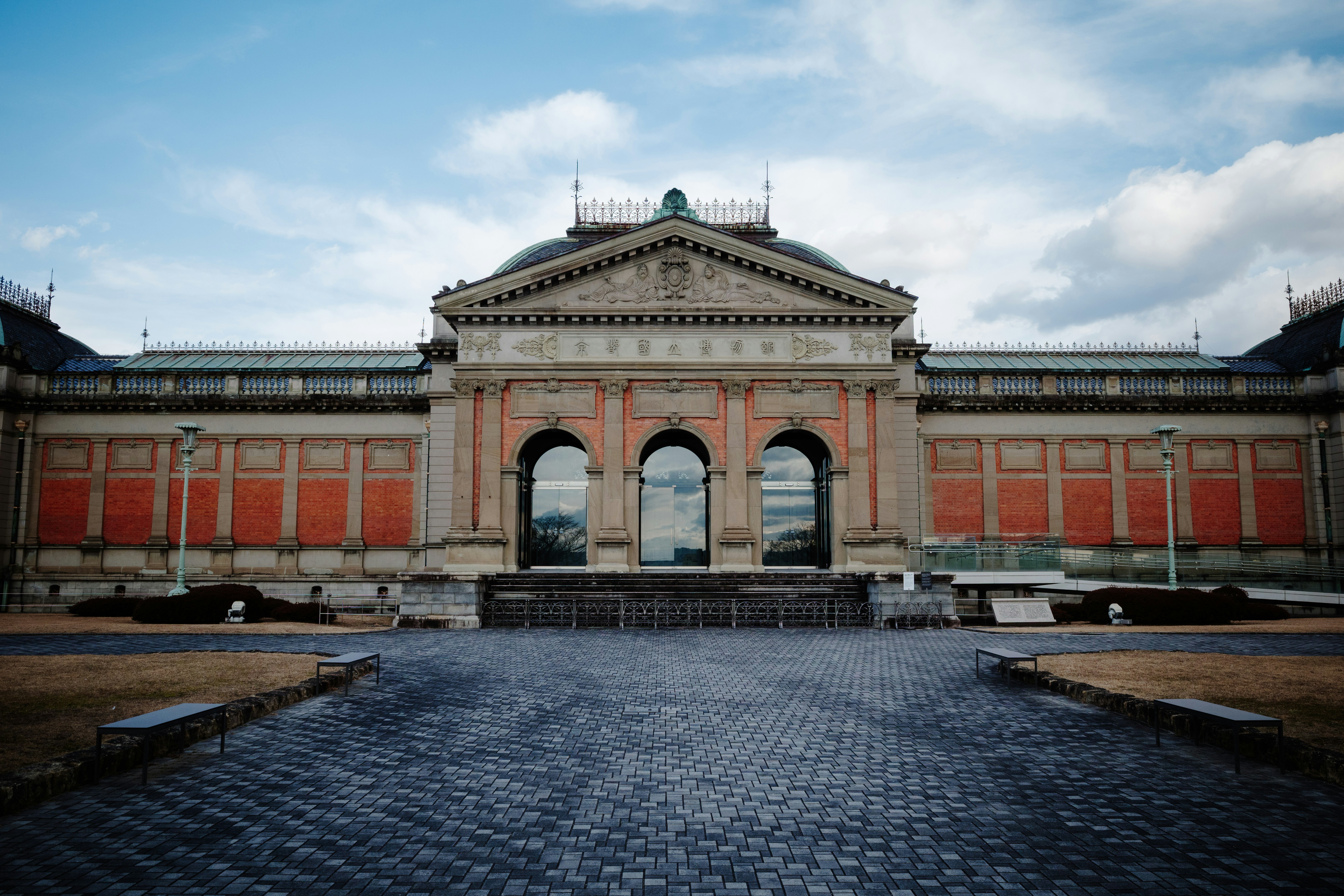 Symmetrical Pavilion: Red Brick Facade Under a Blue Sky
