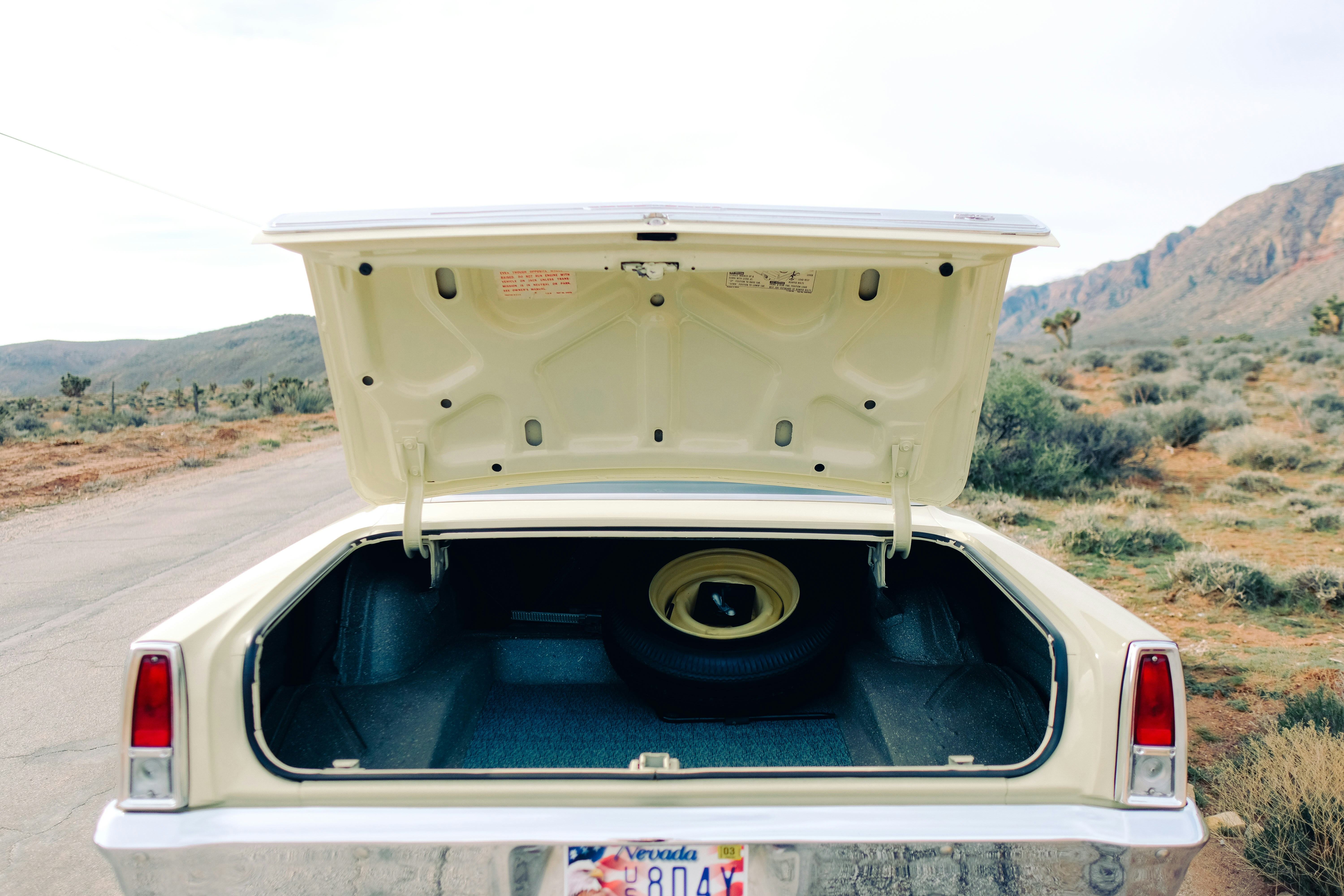 Trunk Open, Desert Road — A Vintage Sedan on a Quiet Horizon
