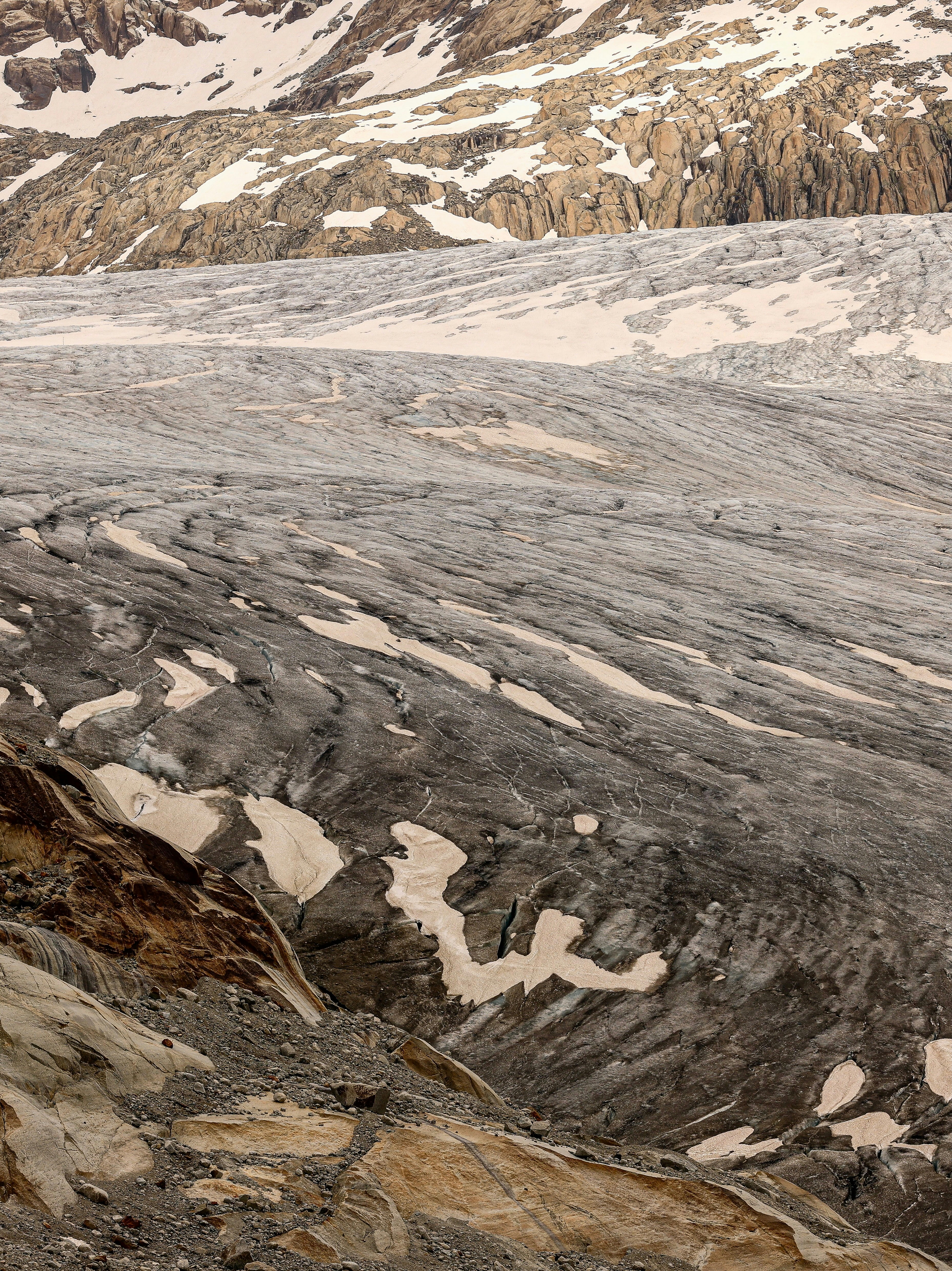 A vast glacier with rocky terrain and snow patches. photo – Free Snow ...