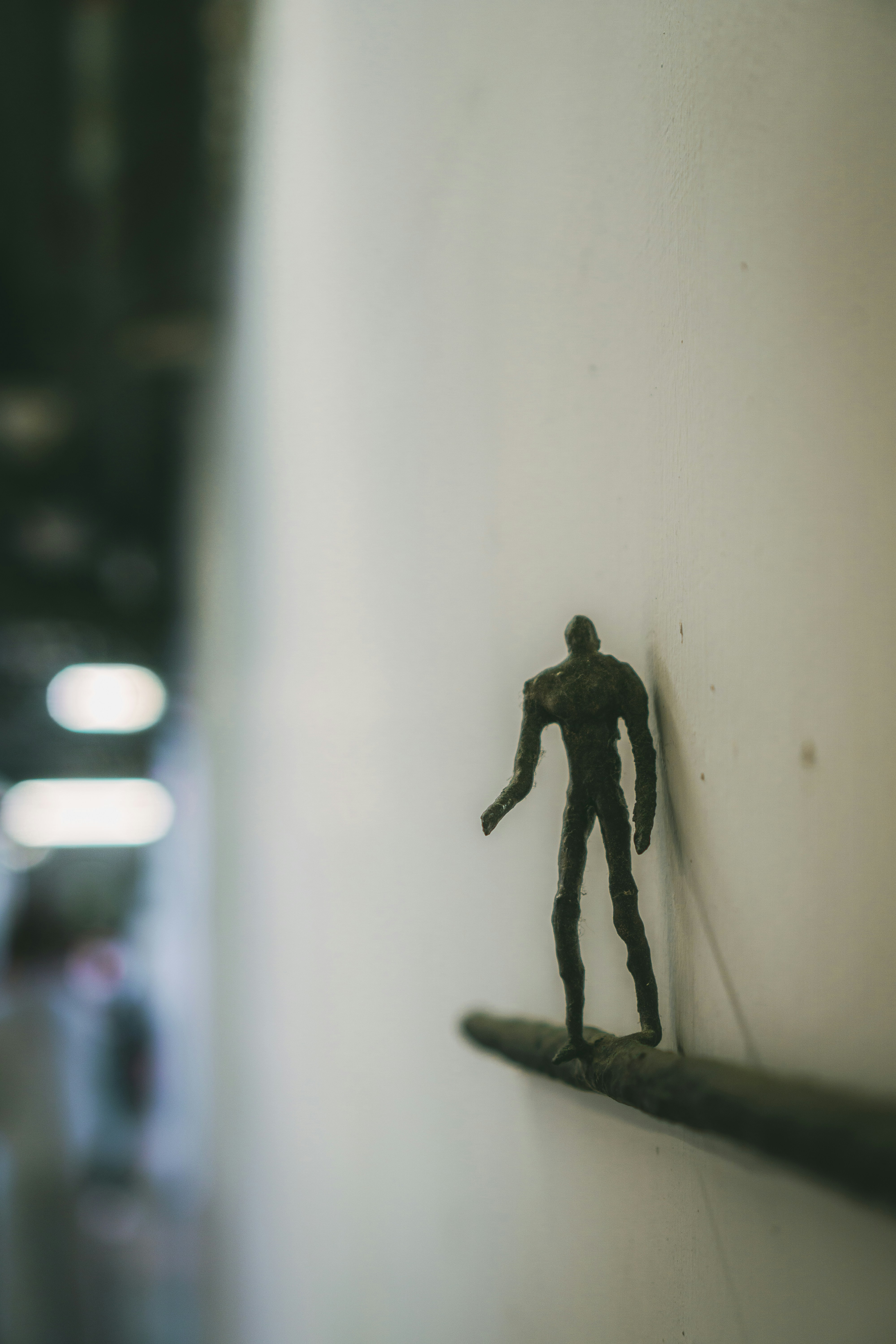 Miniature Samaritan: A Tiny Figure on a White Wall